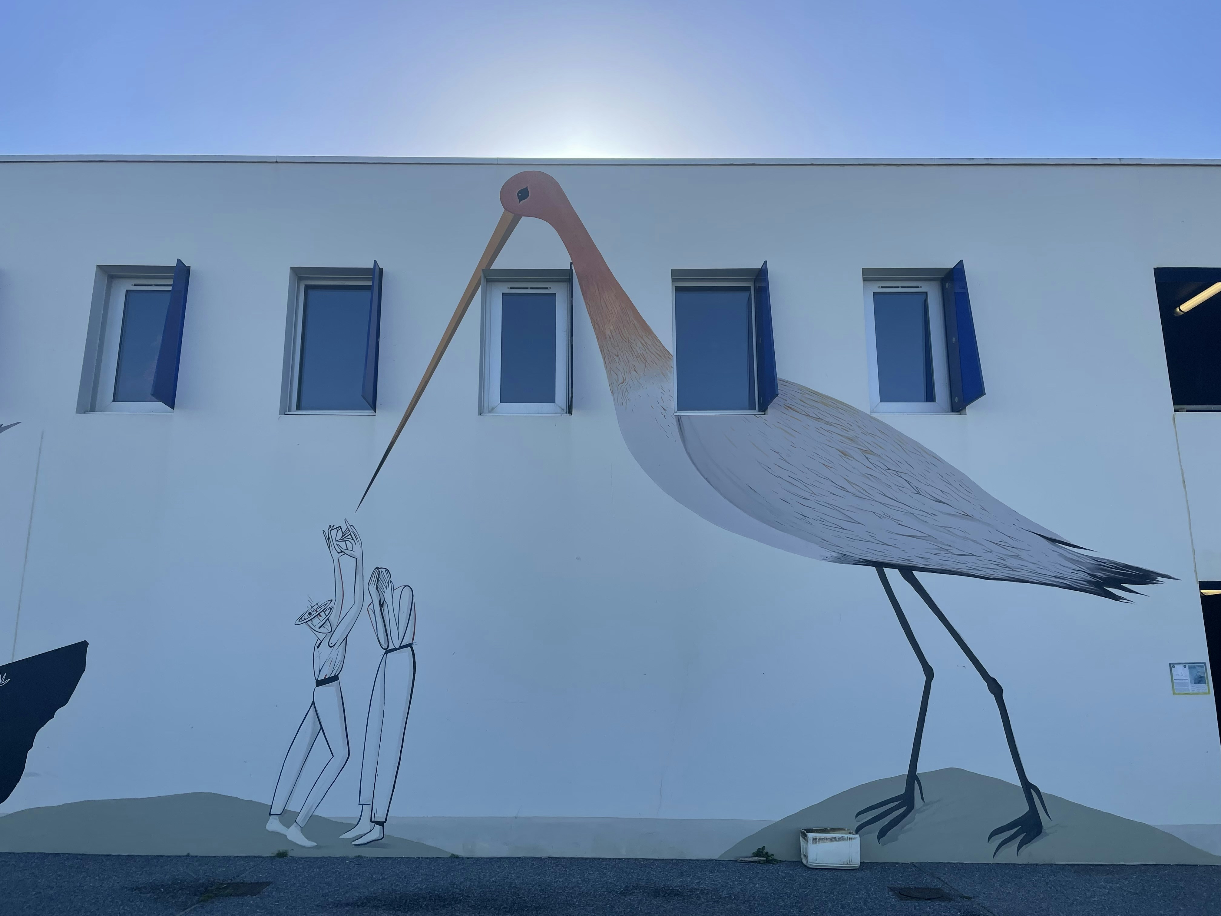 Crane on a White Wall: A Minimalist Mural Reaching Toward the Sky