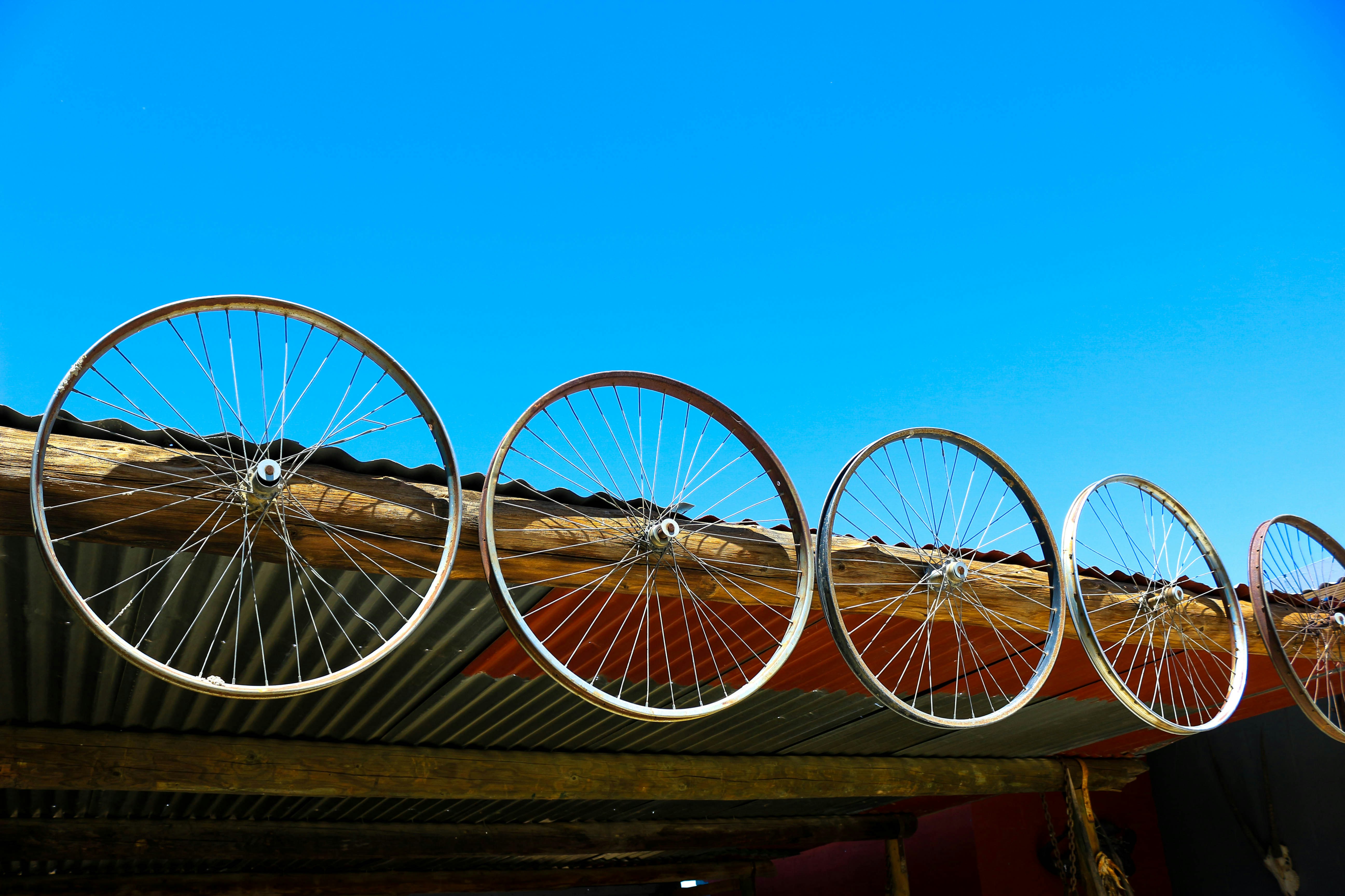 a row of bicycle wheels sitting on top of a roof