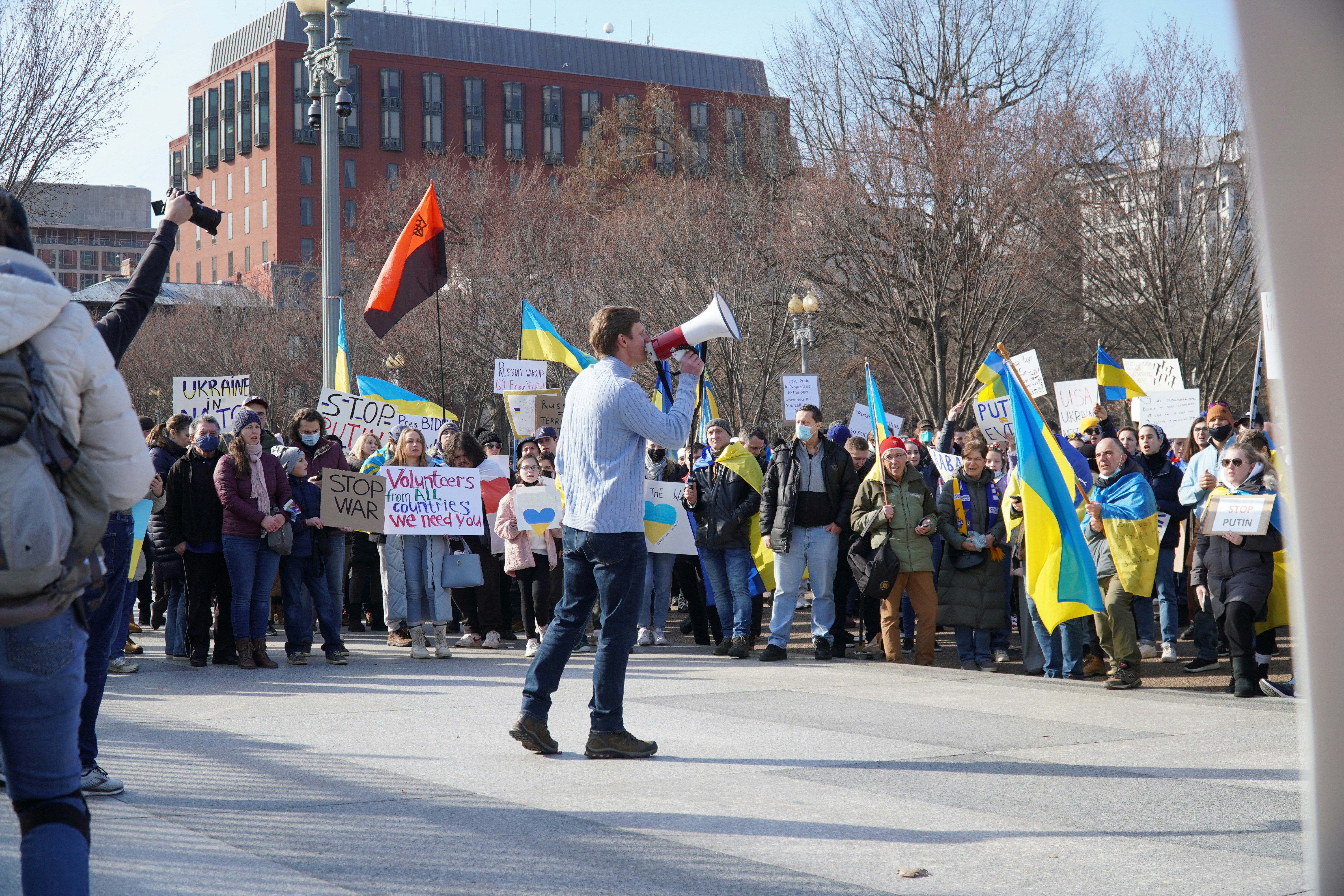 A group of people marching down a street photo – Free White house Image ...