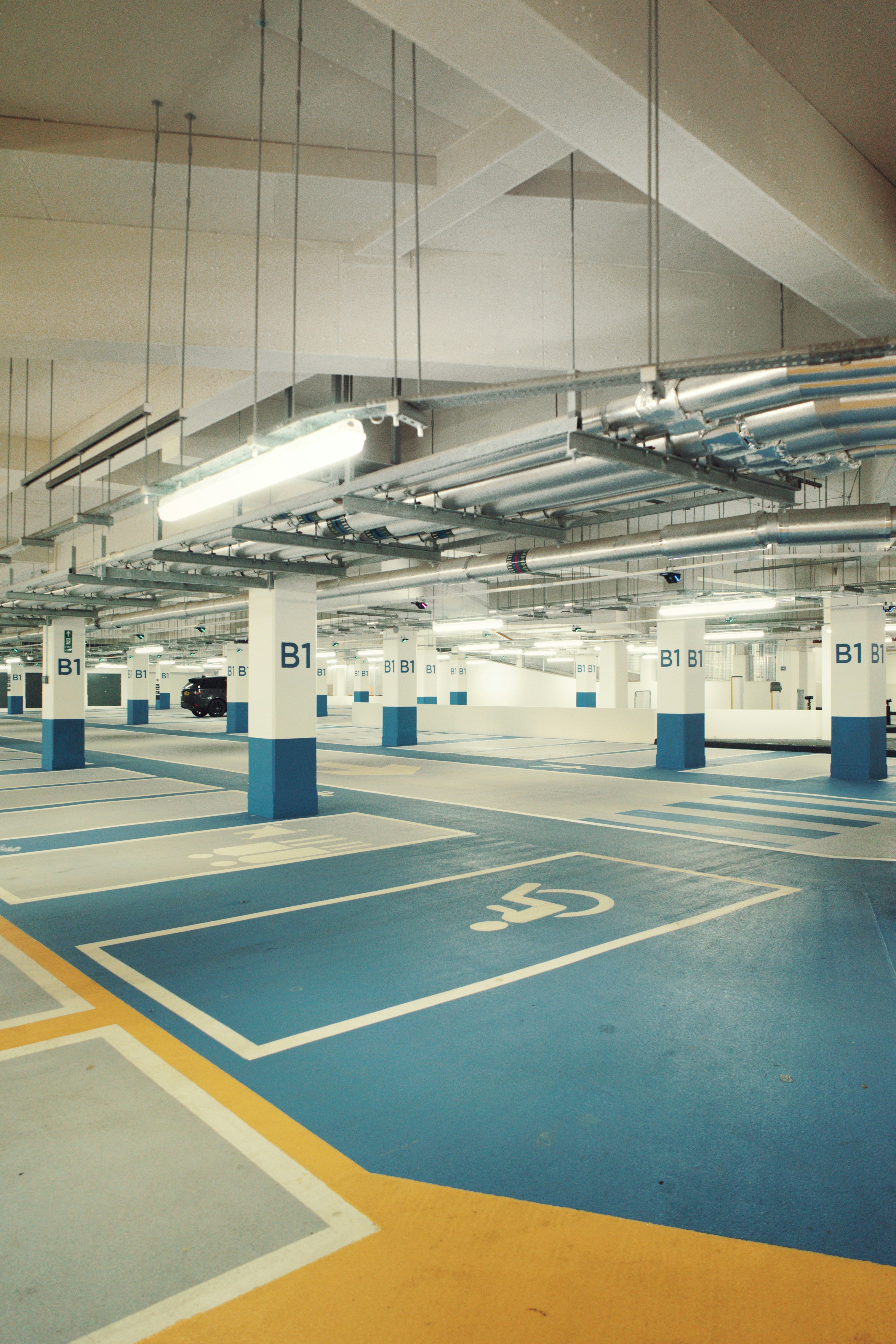 An empty parking garage with blue and yellow flooring photo – Free Grey ...