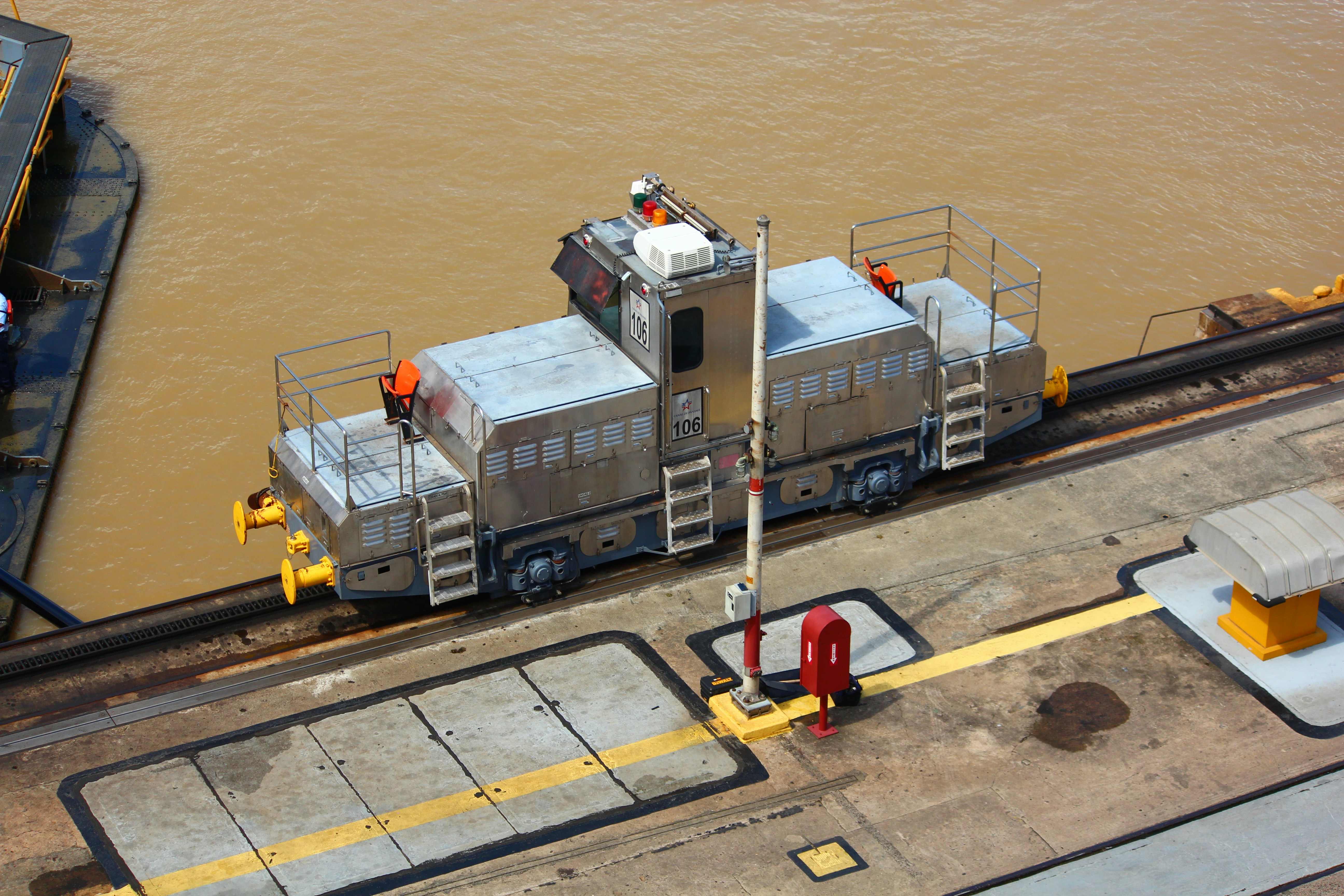 Gray locomotive on tracks beside the Panama Canal waterway.