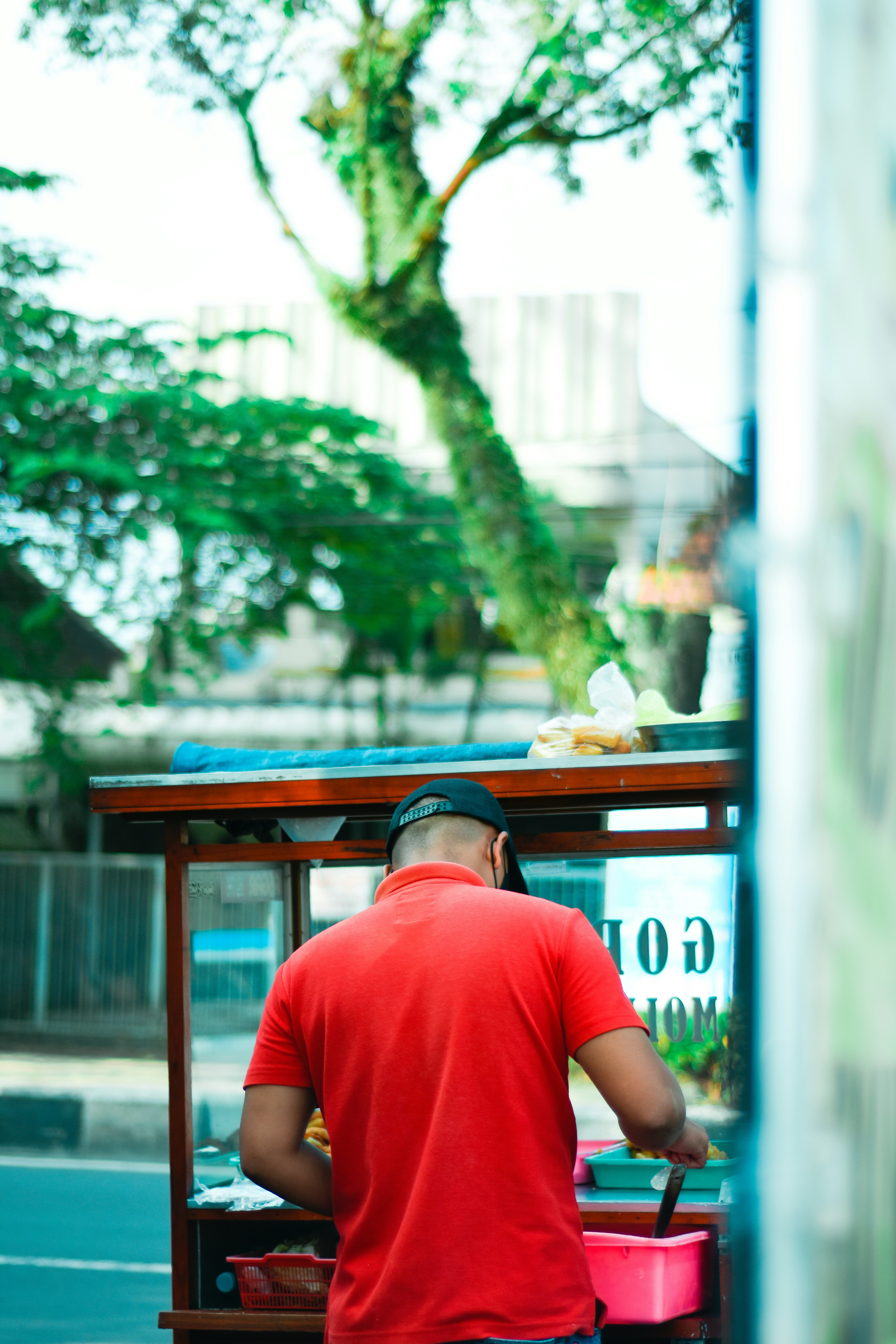 a man standing behind a food cart selling food
