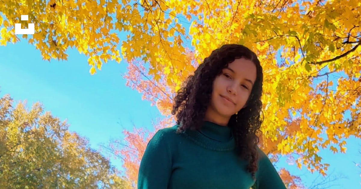 Foto Una Mujer Parada Debajo De Un árbol Con Hojas En El Suelo Imagen