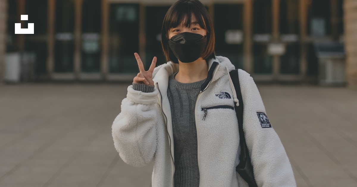 건물 앞에 서 있는 안면 마스크를 쓴 여성 사진 Unsplash의 무료 의류 이미지
