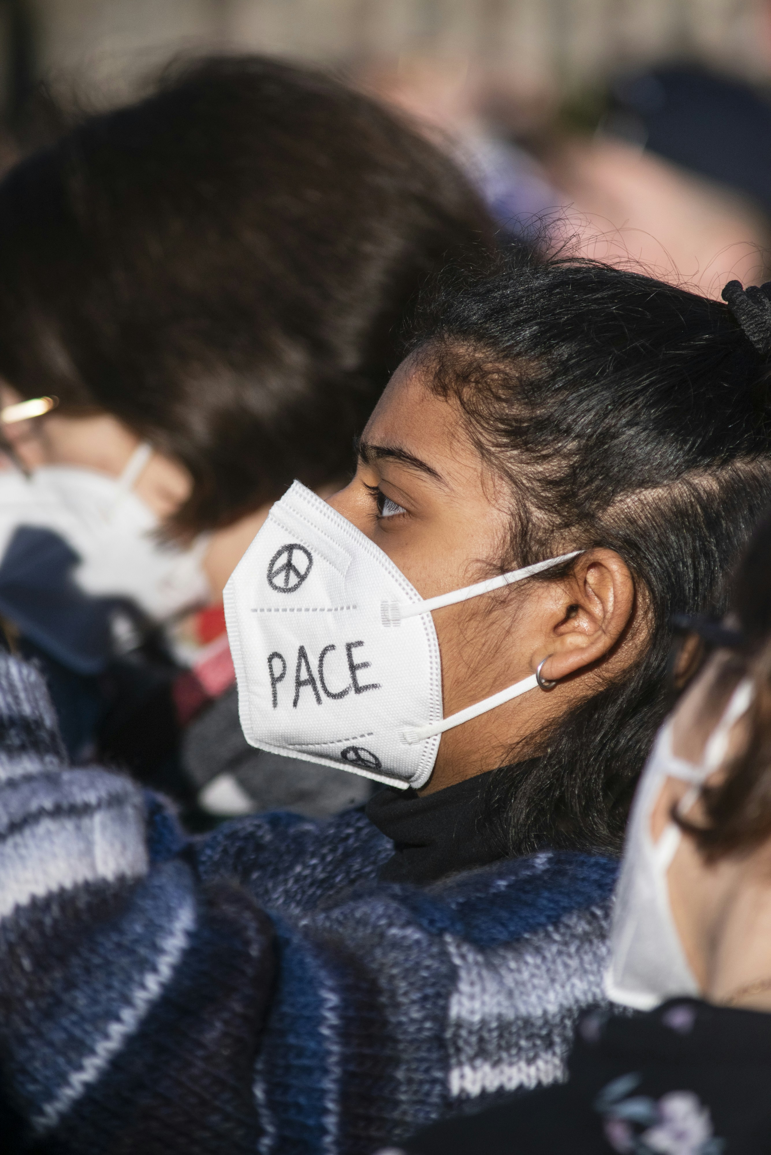 A woman wearing a face mask with a peace sign on it photo – Free Milano ...