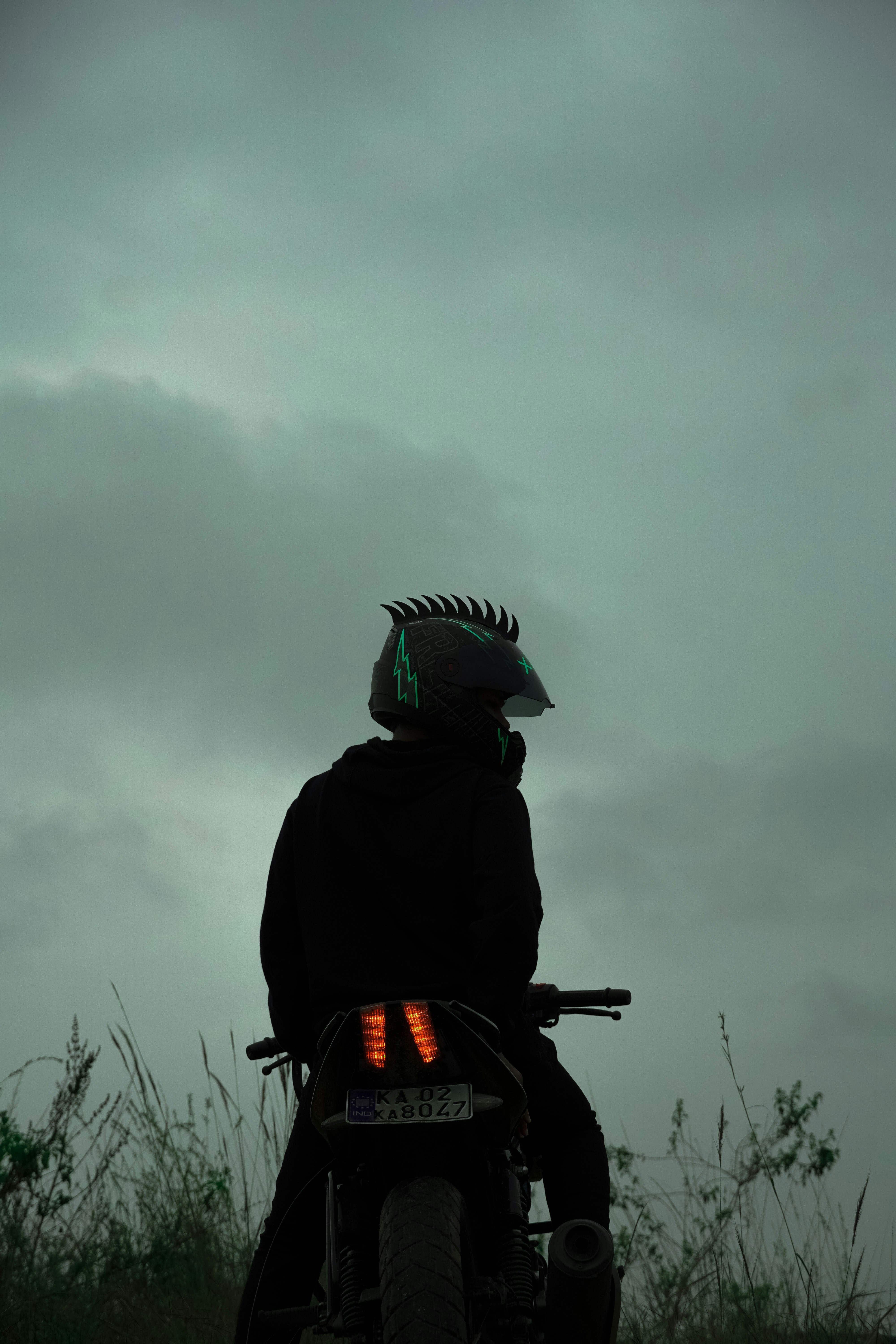 Neon-Accented Helm on a Lone Rider Beneath a Storm-Scarred Sky