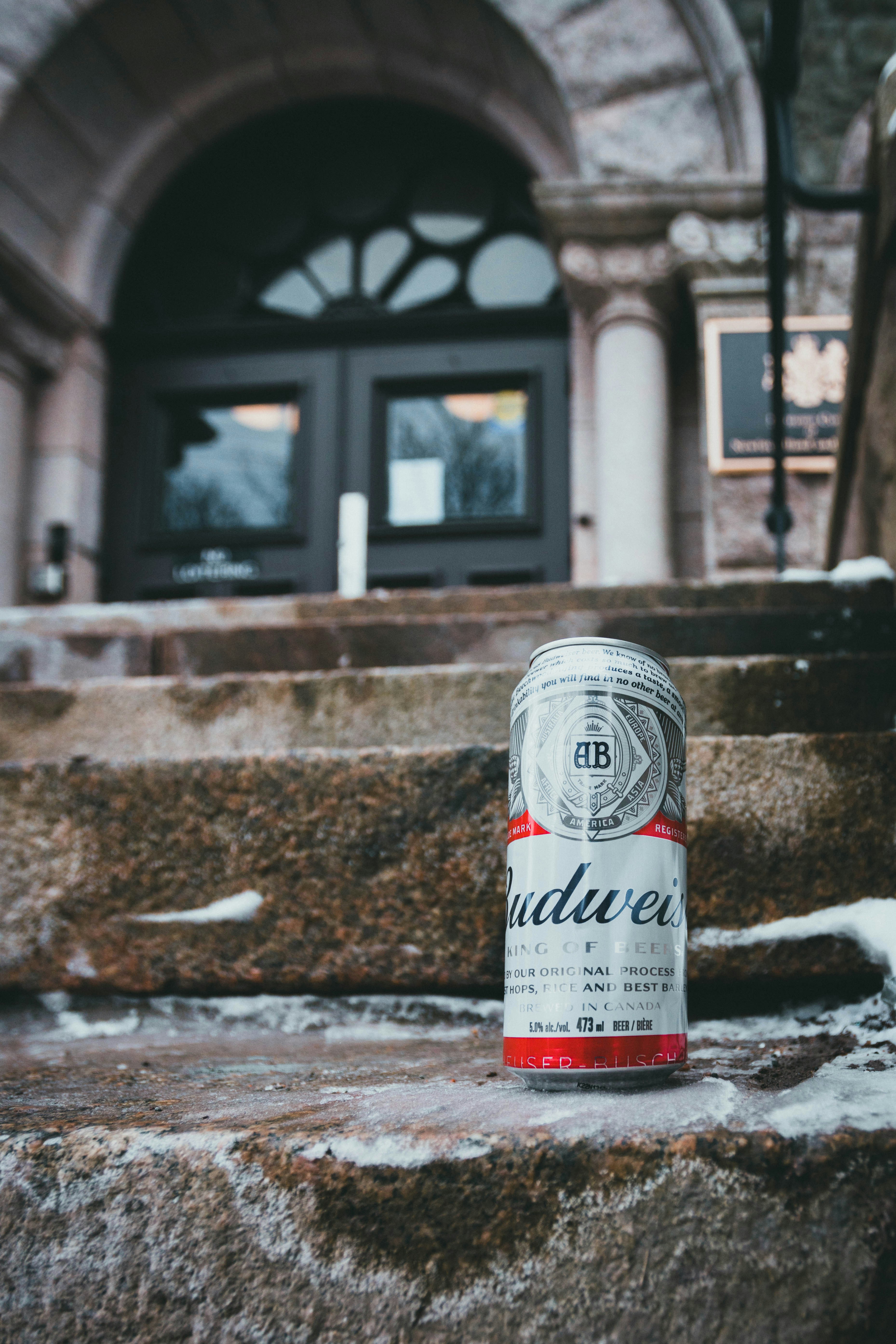 Budweiser on the Stairs: Quiet Resilience of a Snow-Dusted Entrance