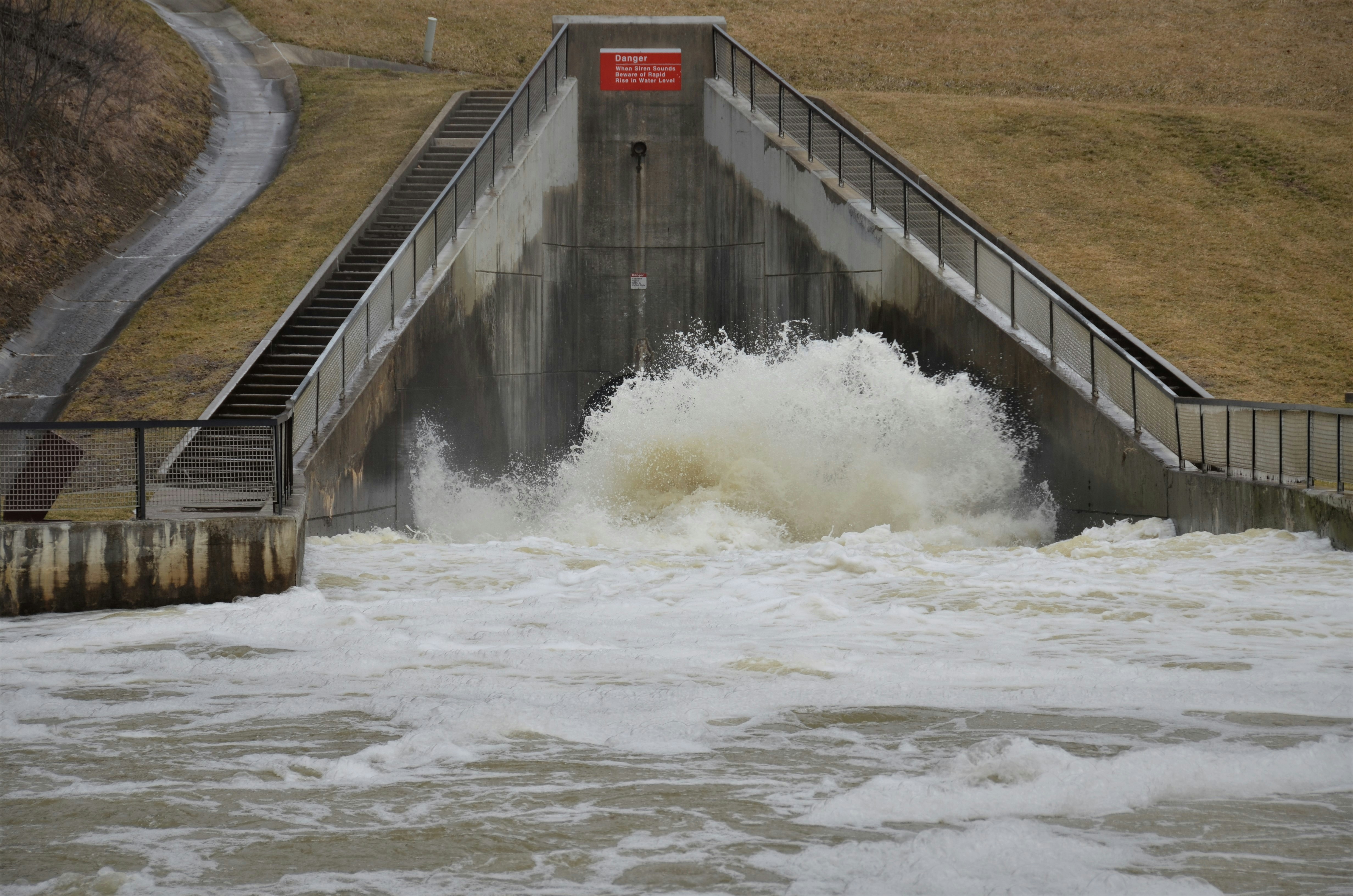 Rushing Confluence: Water Surges Over the Dam Steps