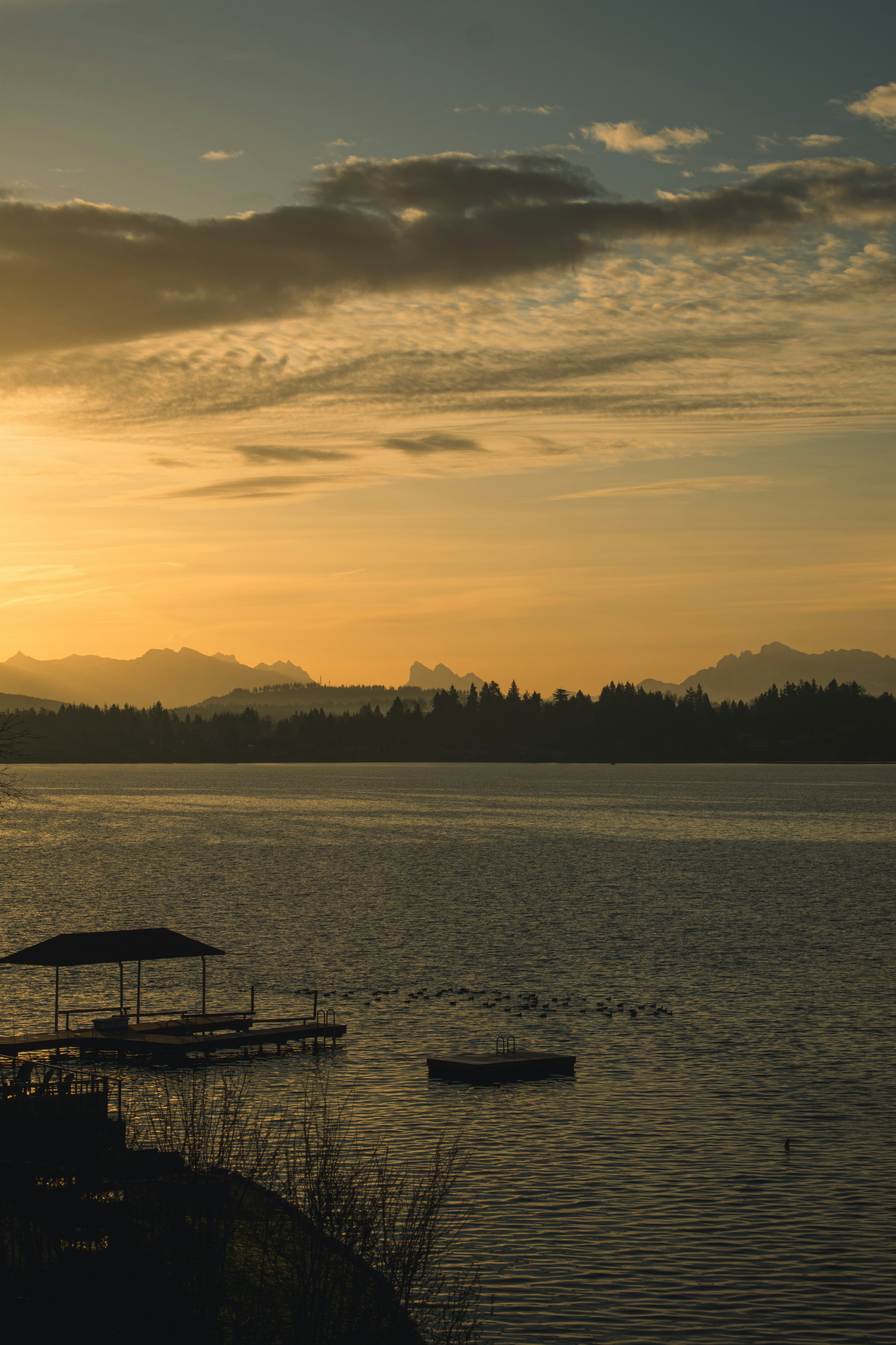 Golden Quiet: Dusk over the Lake with a Robed Pier