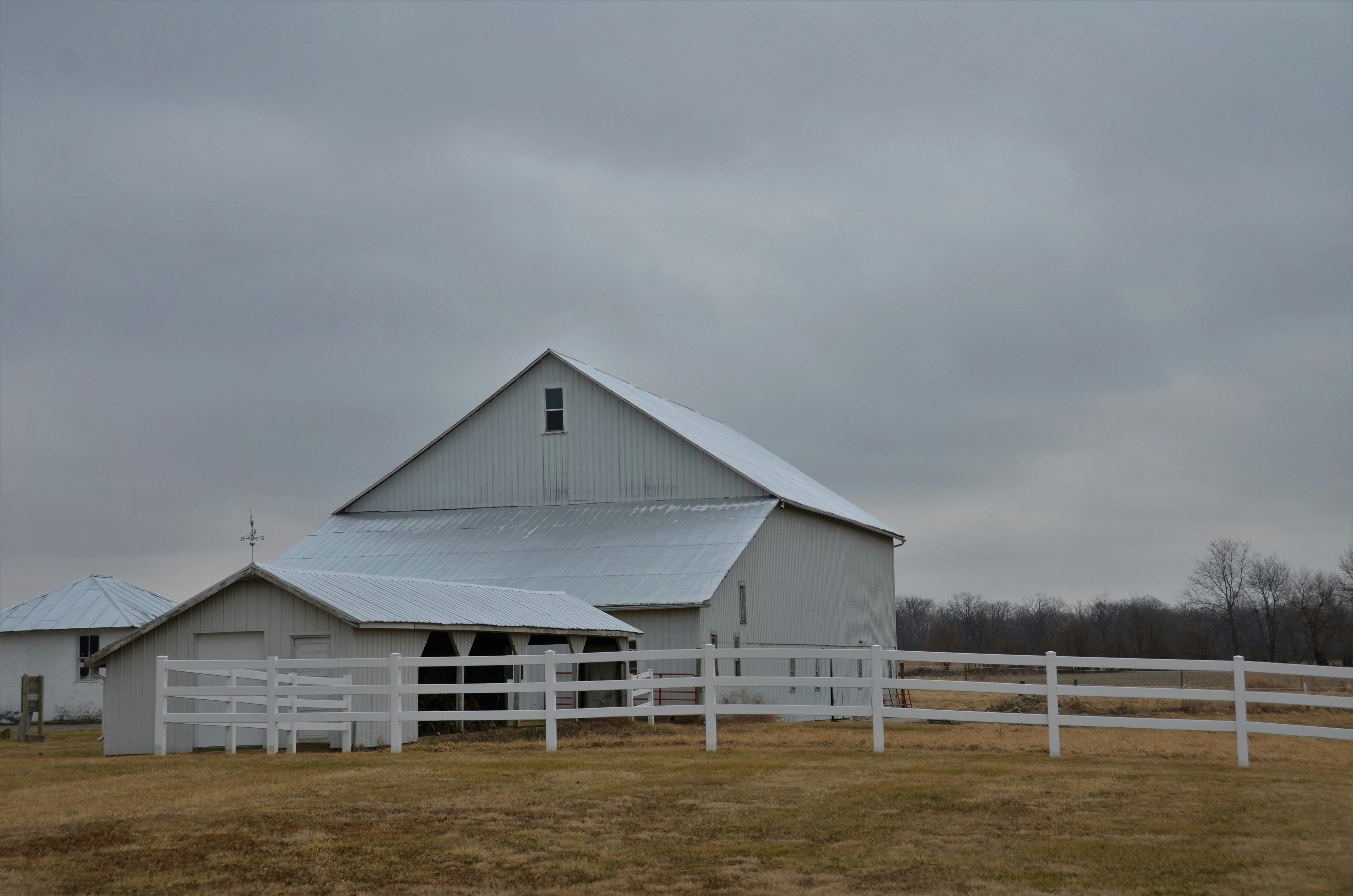 A large white barn with a white fence photo – Free Nature Image on Unsplash