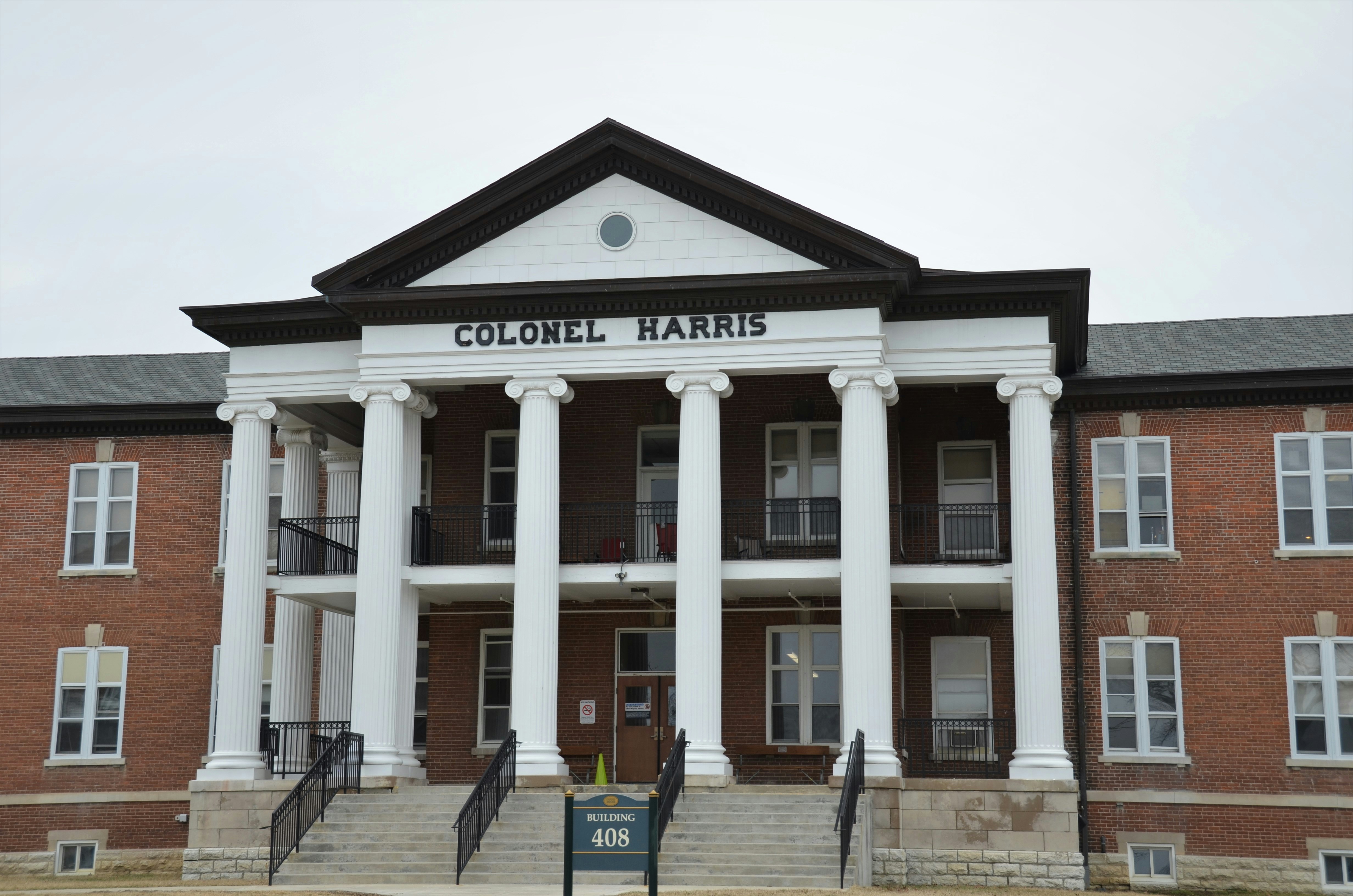 A tall building with columns and a sign in front of it photo – Free ...