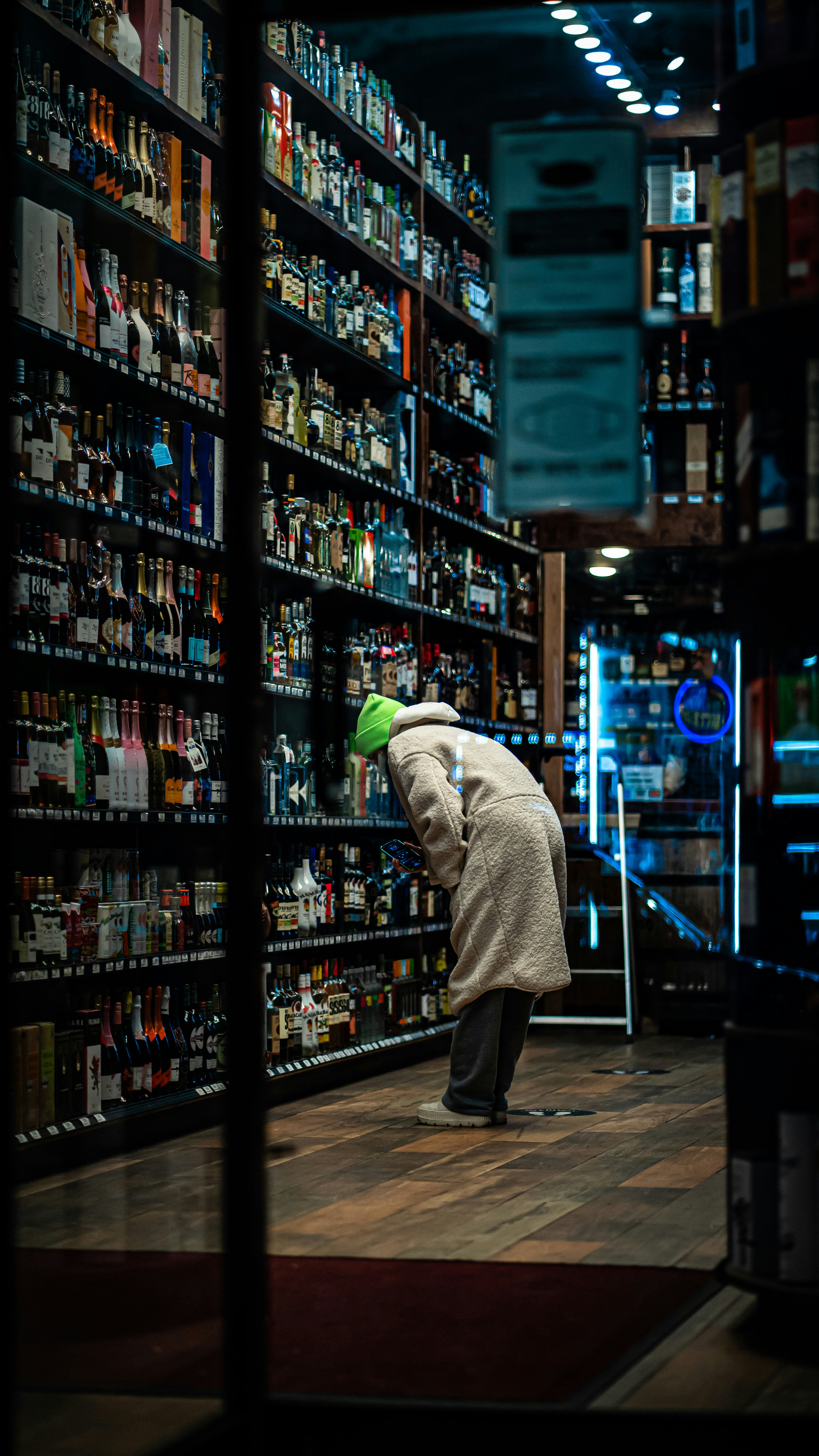 A person bending over in a store filled with shelves photo – Free Shelf ...