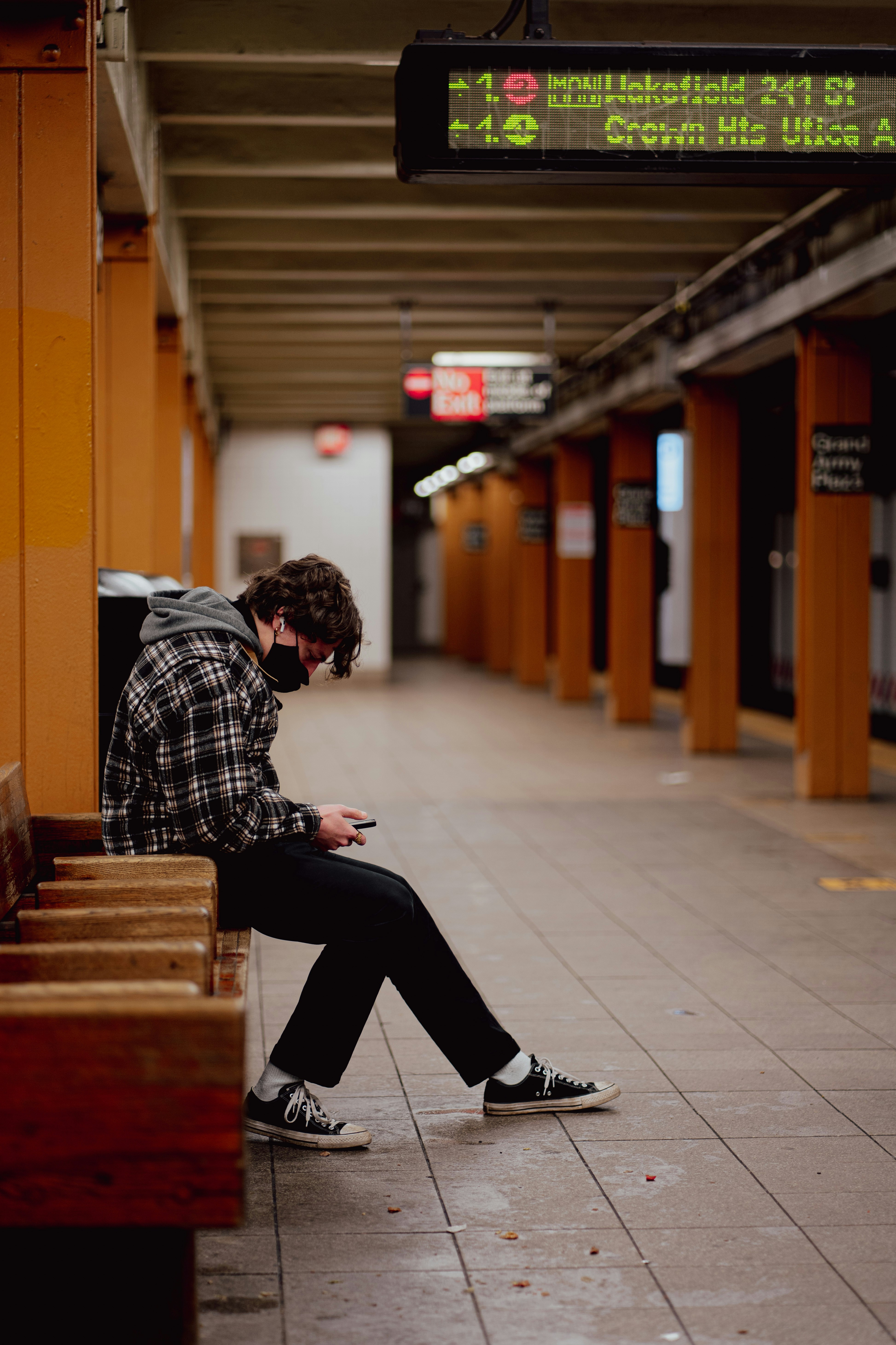 Un homme assis sur un banc regardant son téléphone portable photo ...