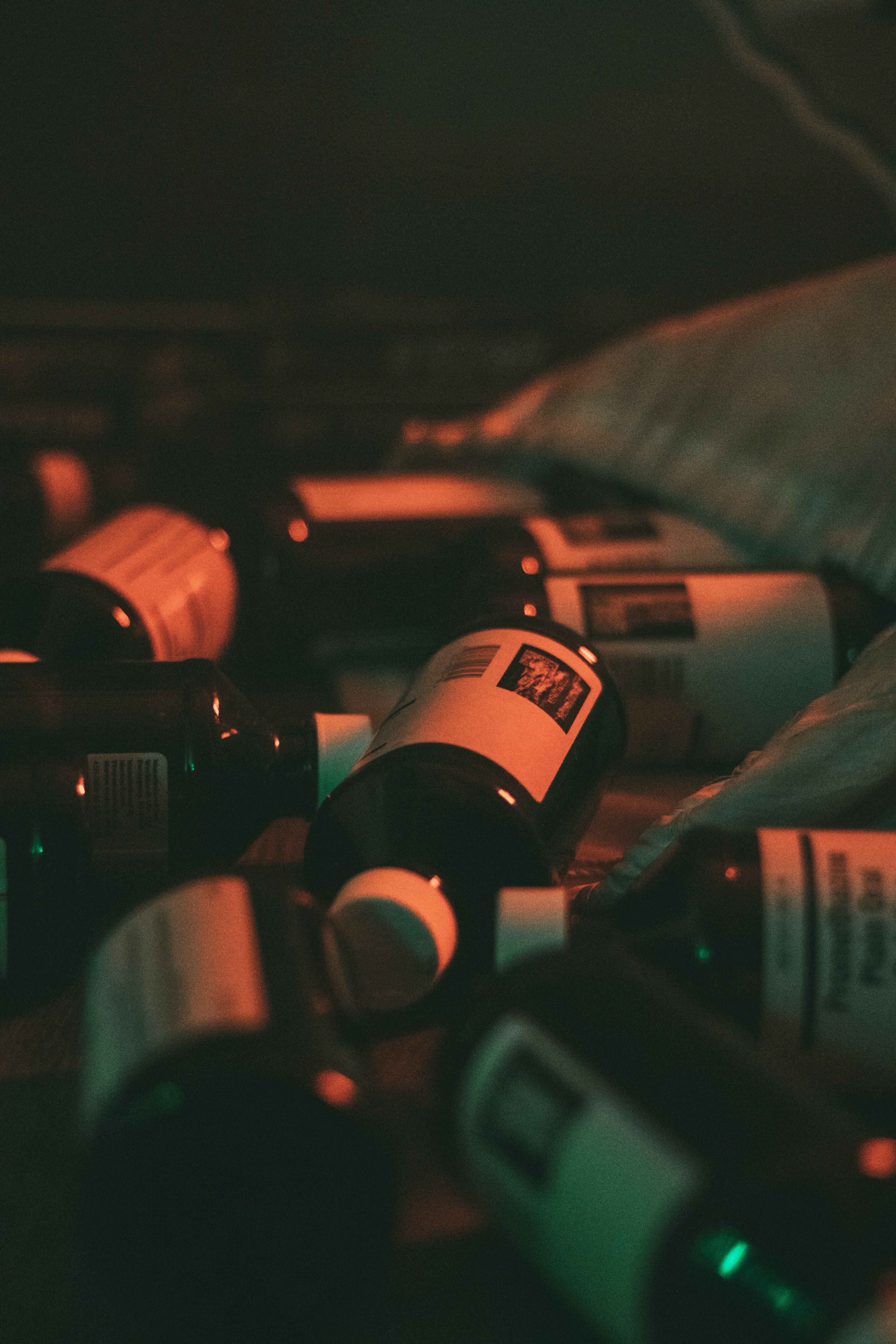Crimson Row: Bottles Quietly Rest in Low Light
