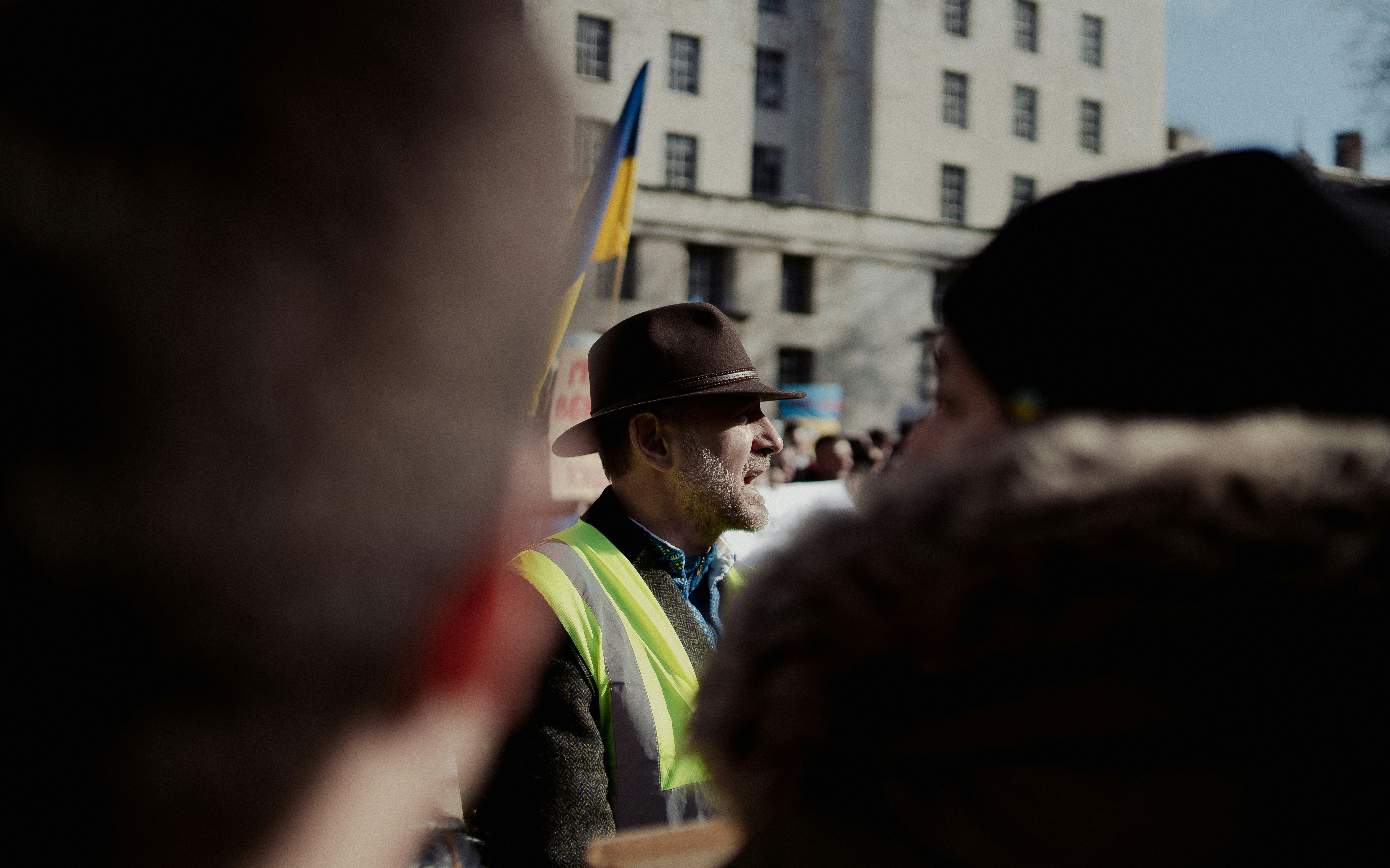 A man in a hat and vest standing in front of a crowd photo – Free ...