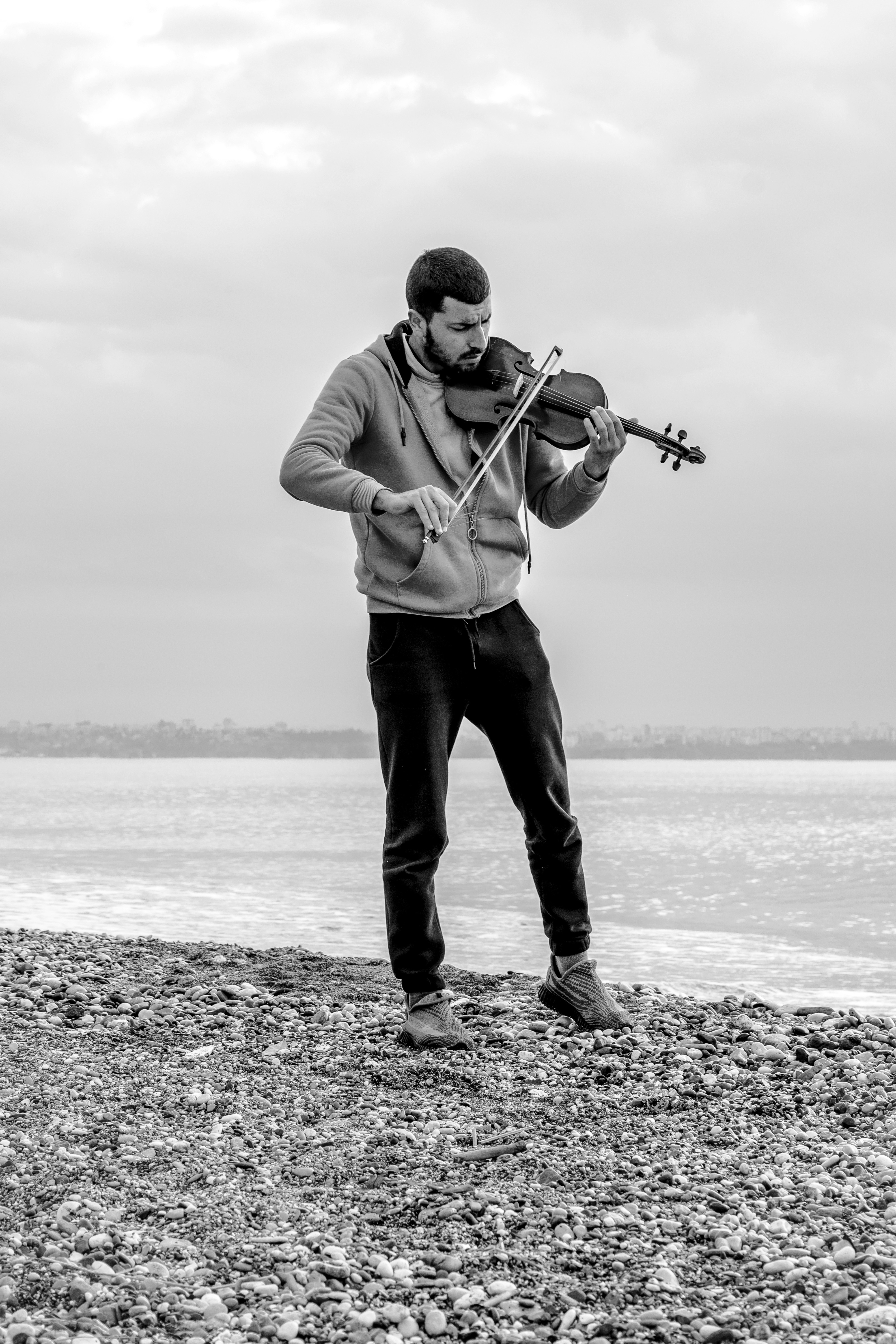 a man playing a violin on the beach