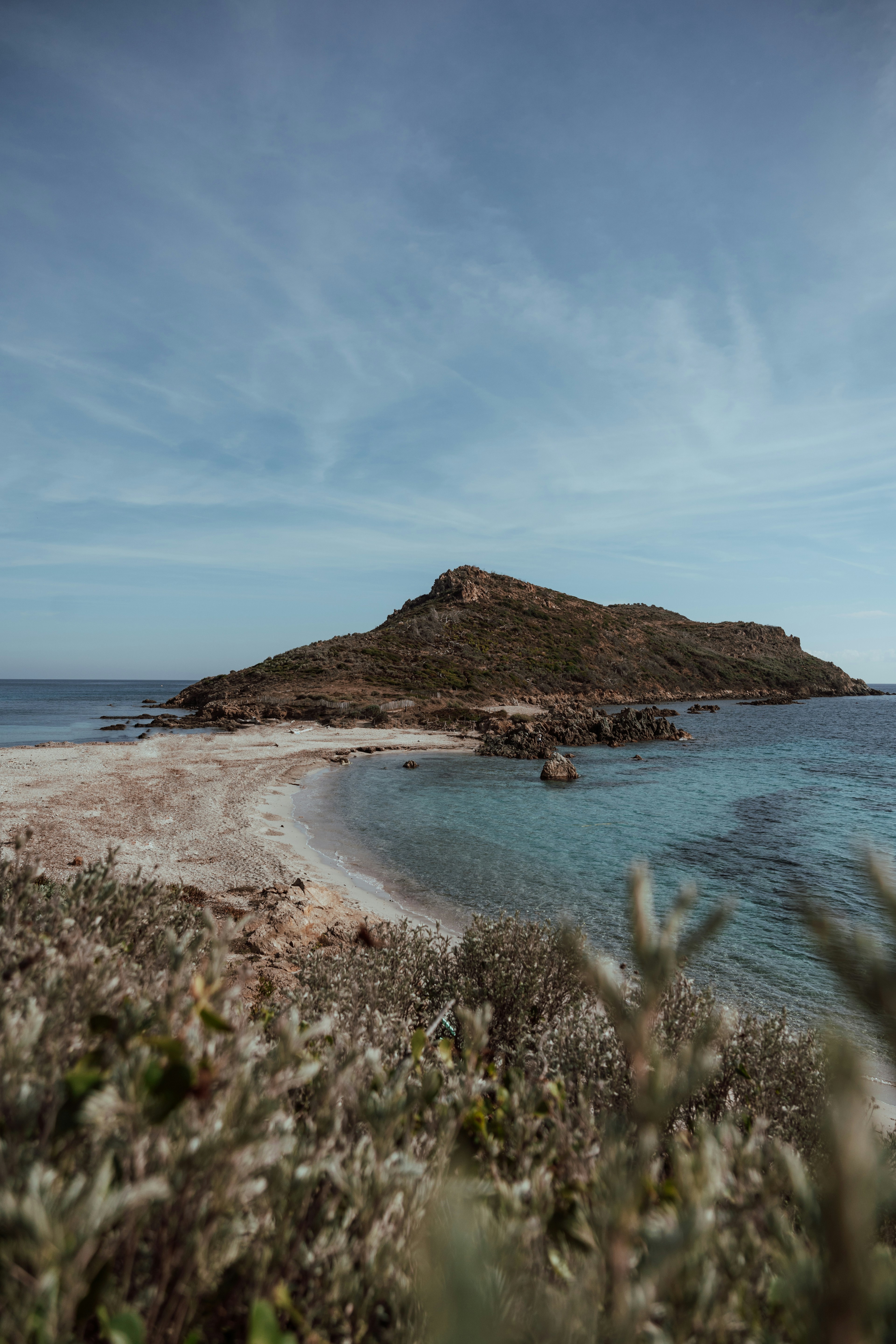 Island Crown: A Rugged Promontory Rising from a Calm Turquoise Bay