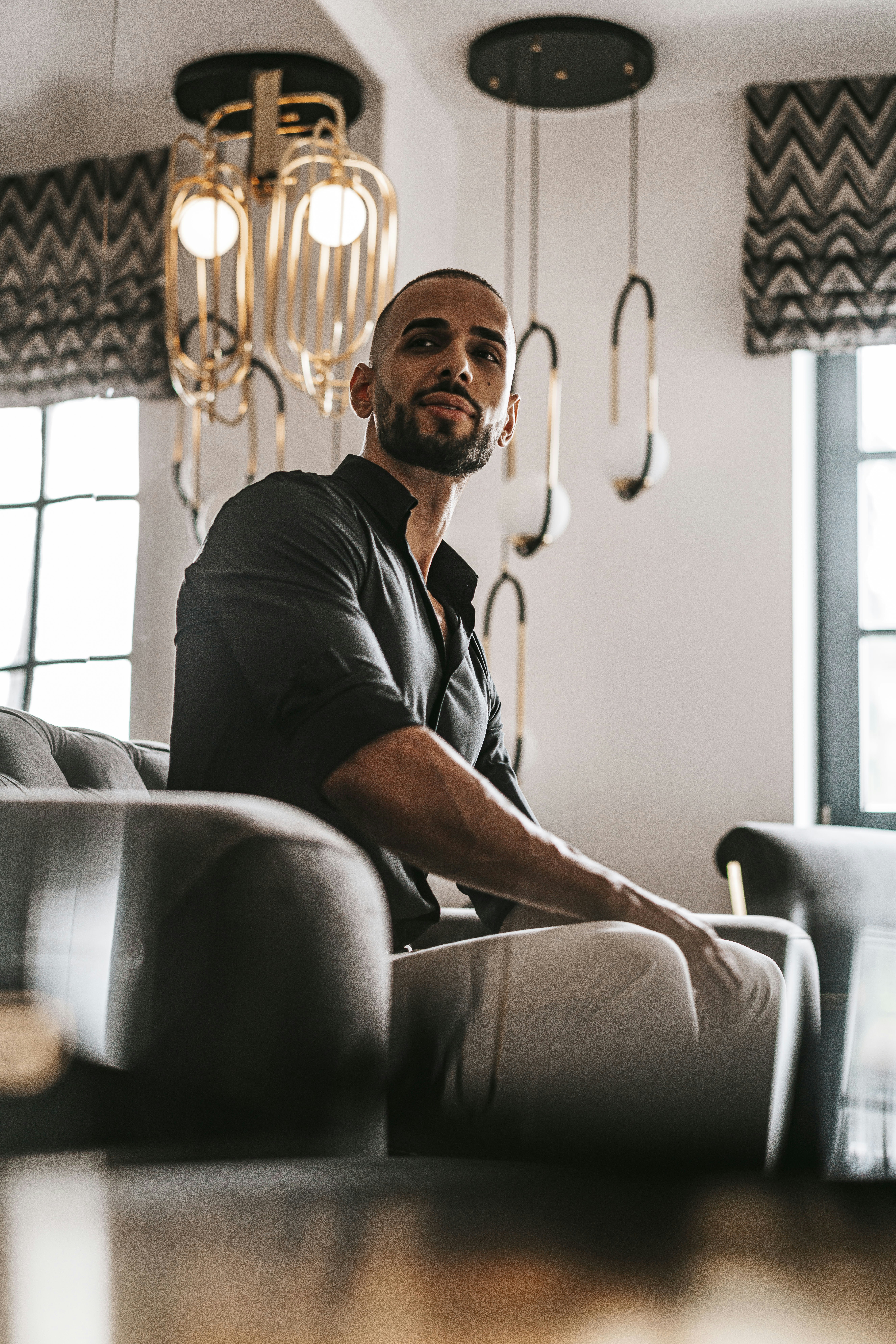 Un homme assis sur un canapé dans un salon photo – Image gratuite de ...