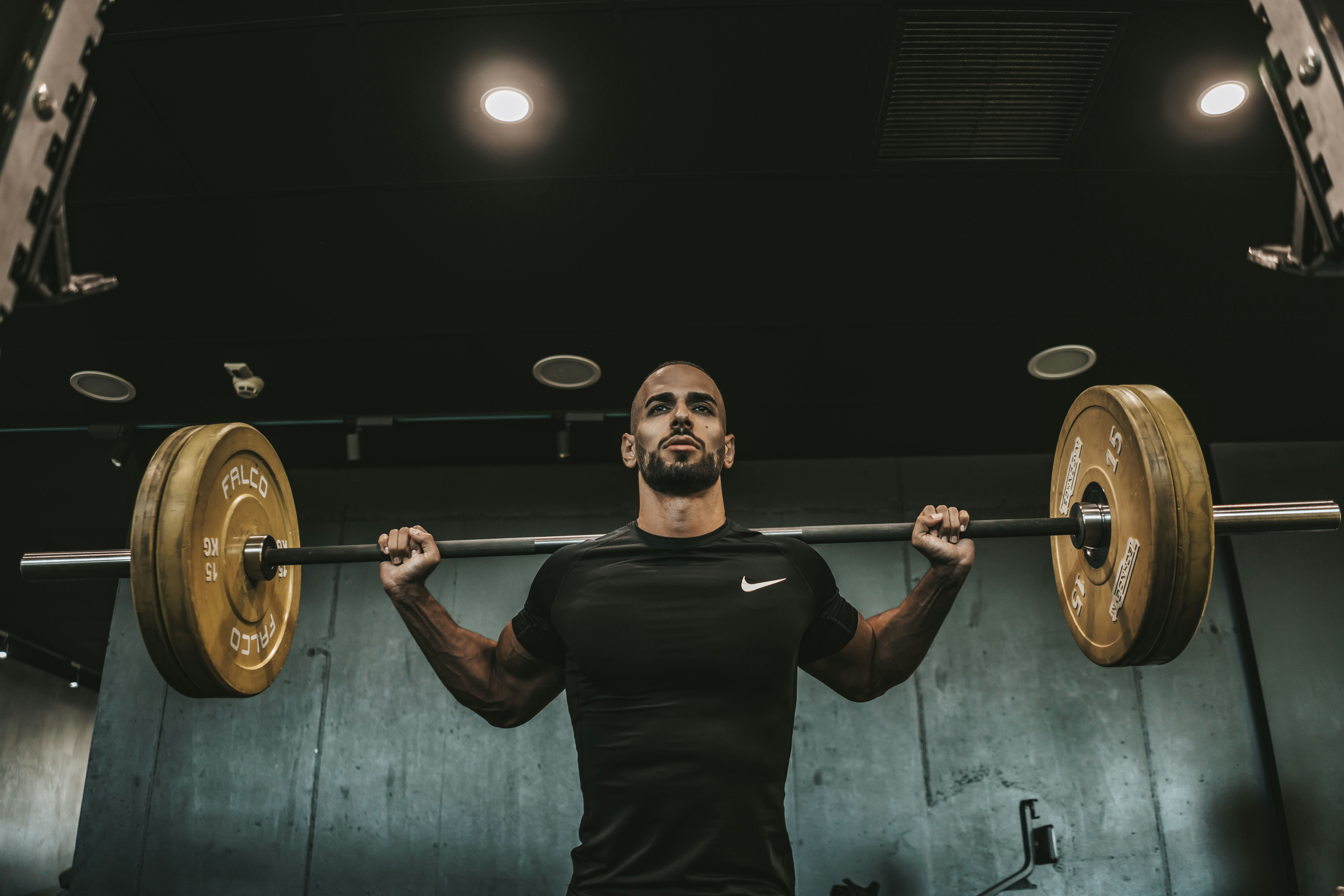 A man lifting a barbell in a gym photo – Free Usa Image on Unsplash