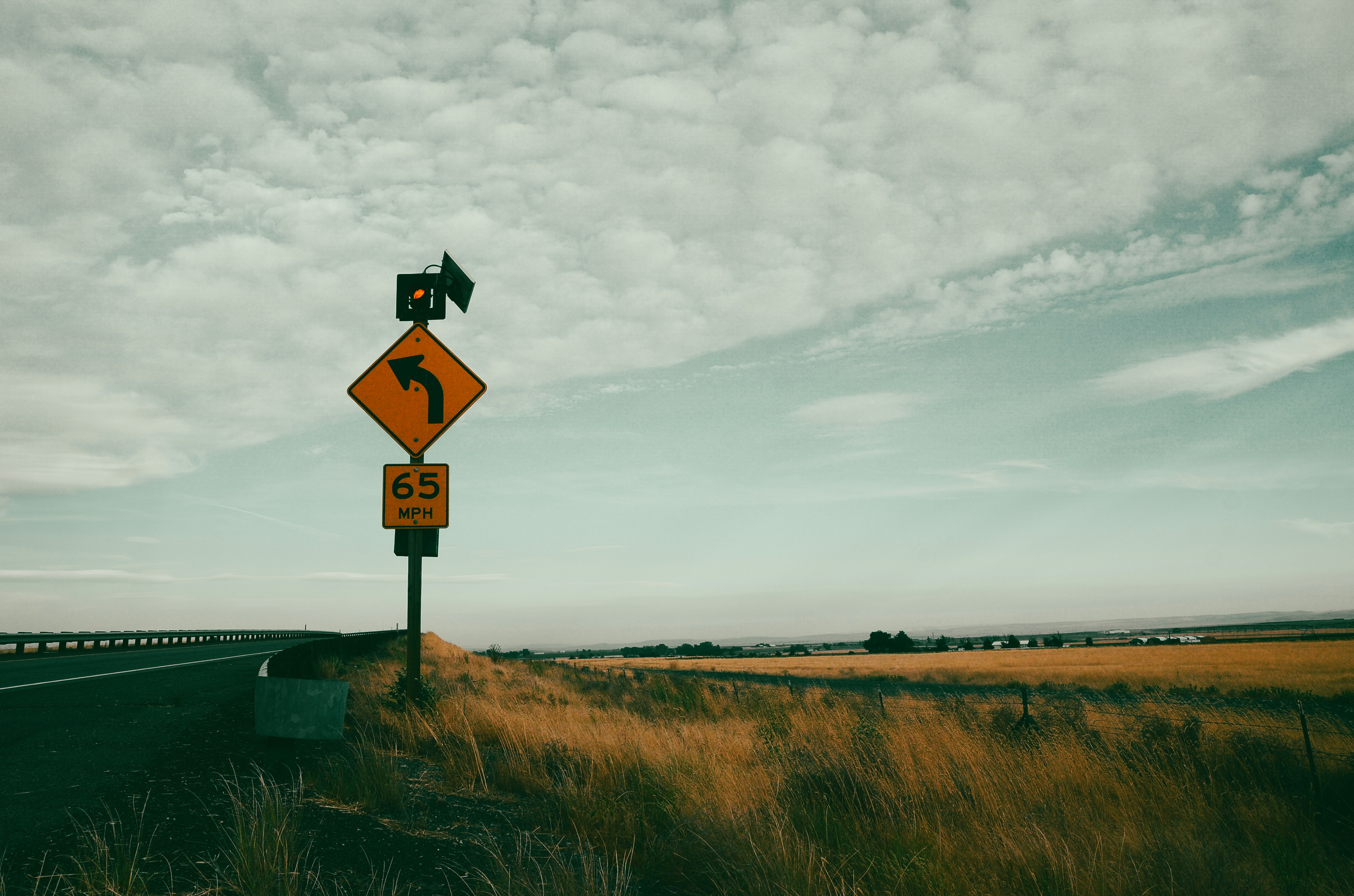 Curve Ahead: The Lone Road Sign Guarding a Golden Prairie