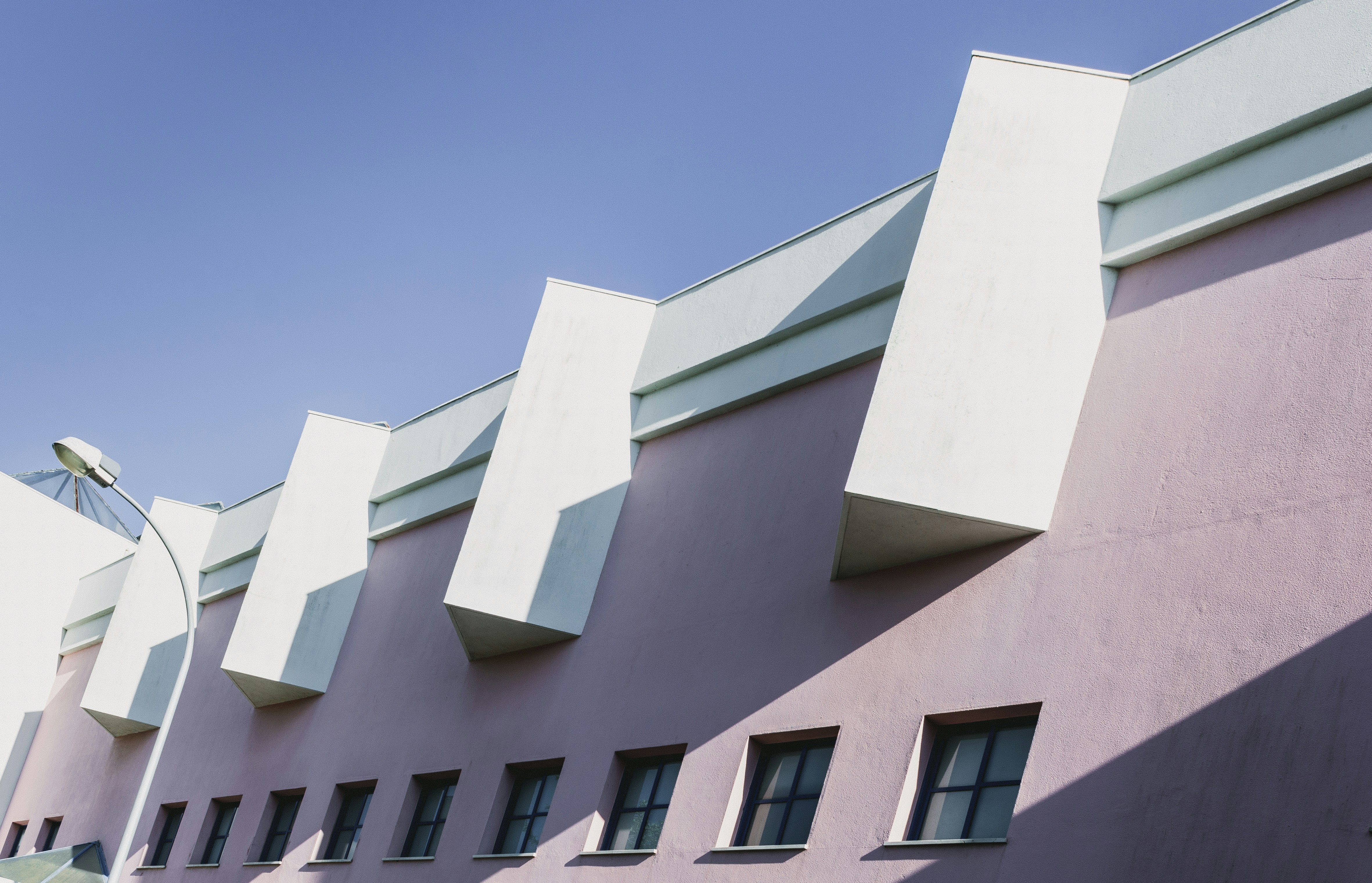 A row of pink buildings with white windows photo – Free Building Image ...