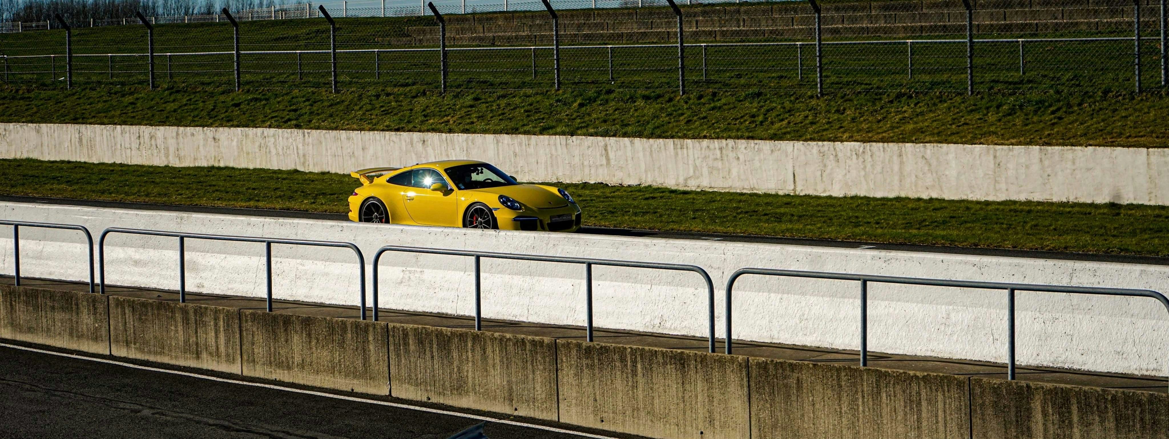 A yellow sports car driving down a highway photo – Free Car Image on ...