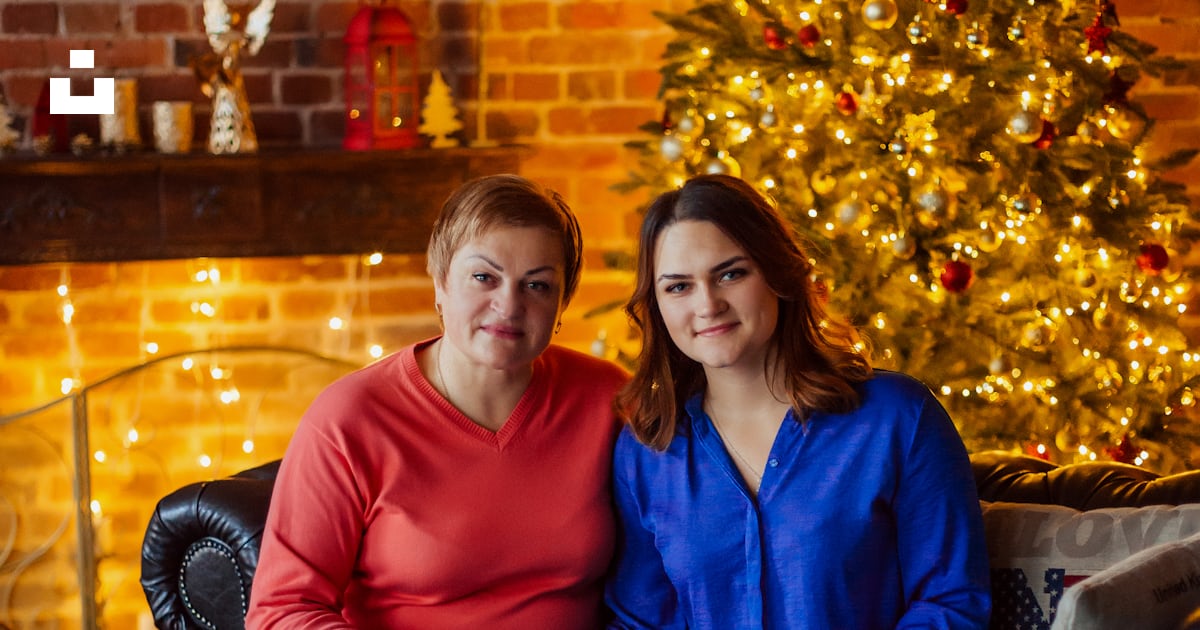 Deux Femmes Assises Sur Un Canapé Devant Un Sapin De Noël Photo Photo