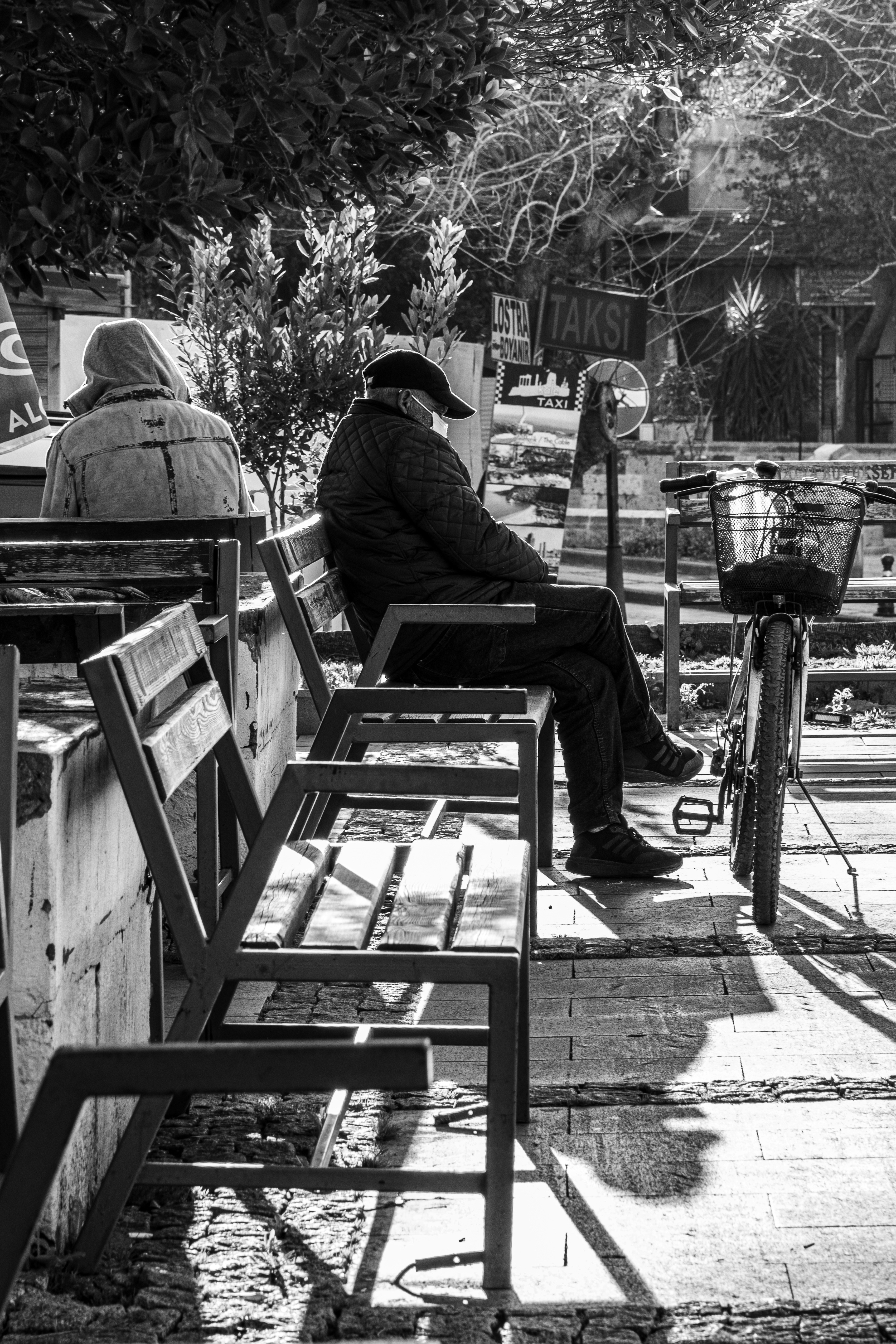 a couple of people sitting on top of a wooden bench