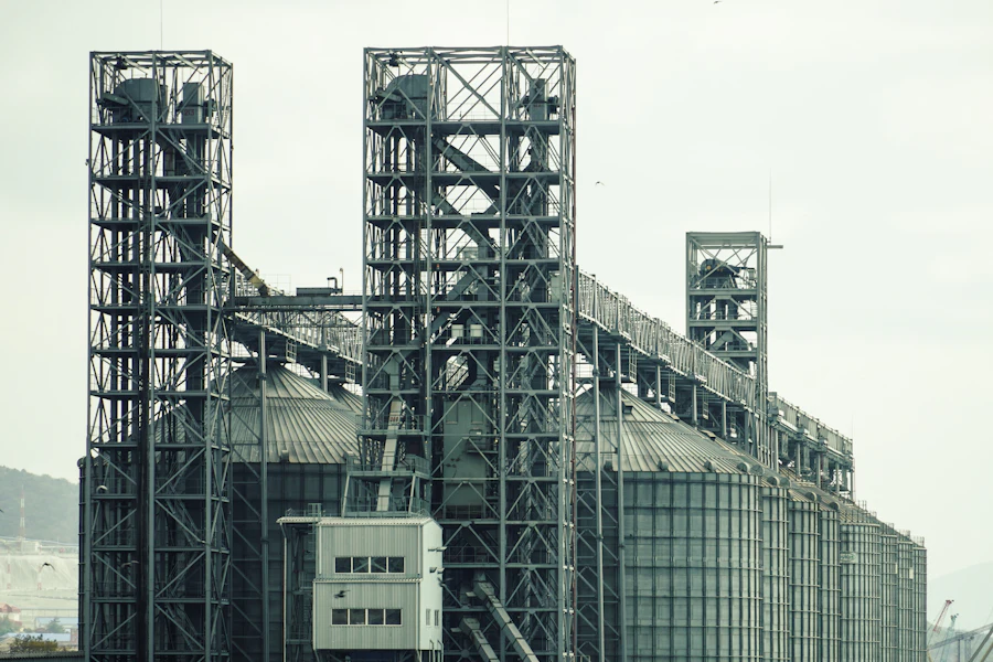 Massive grain silos and towering metal structures dominate the industrial landscape, showcasing modern engineering. The intricate design highlights the functionality and scale of the facility.