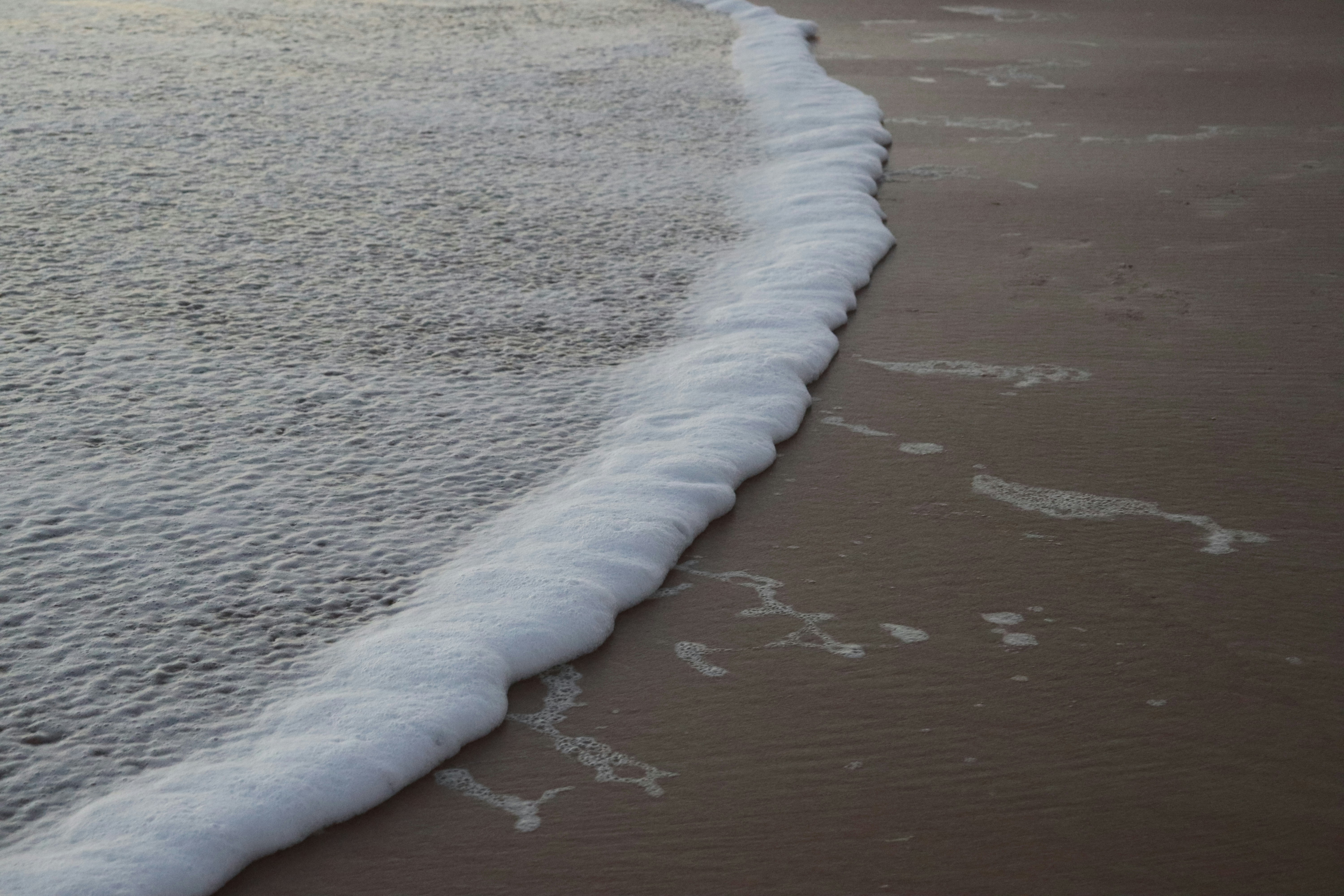 A wave is coming in to the shore of a beach photo – Free Nature Image ...