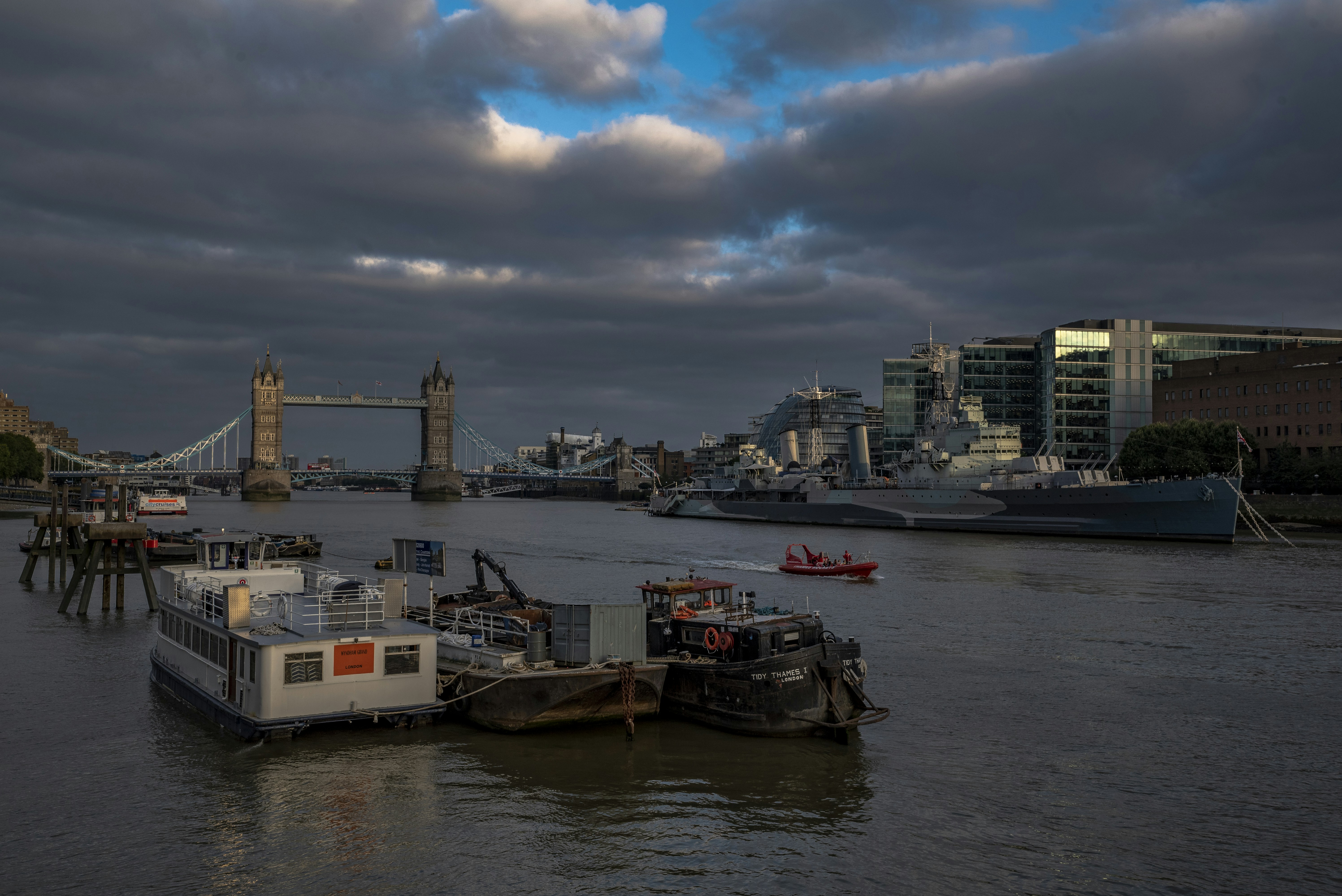 Foto Un barco flotando en la cima de un río junto a un puente – Imagen ...