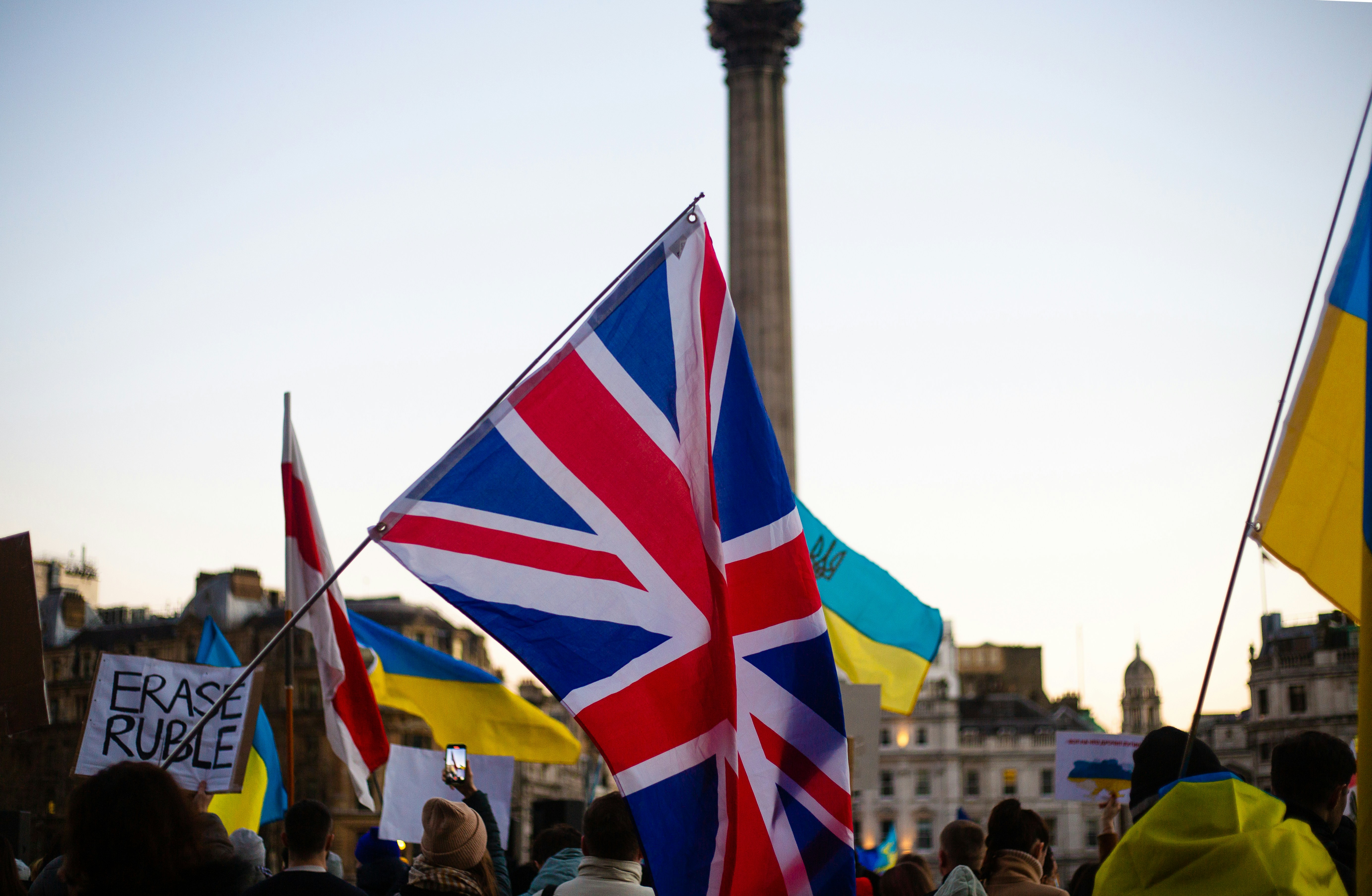 A group of people holding flags and signs photo – Free War protest ...