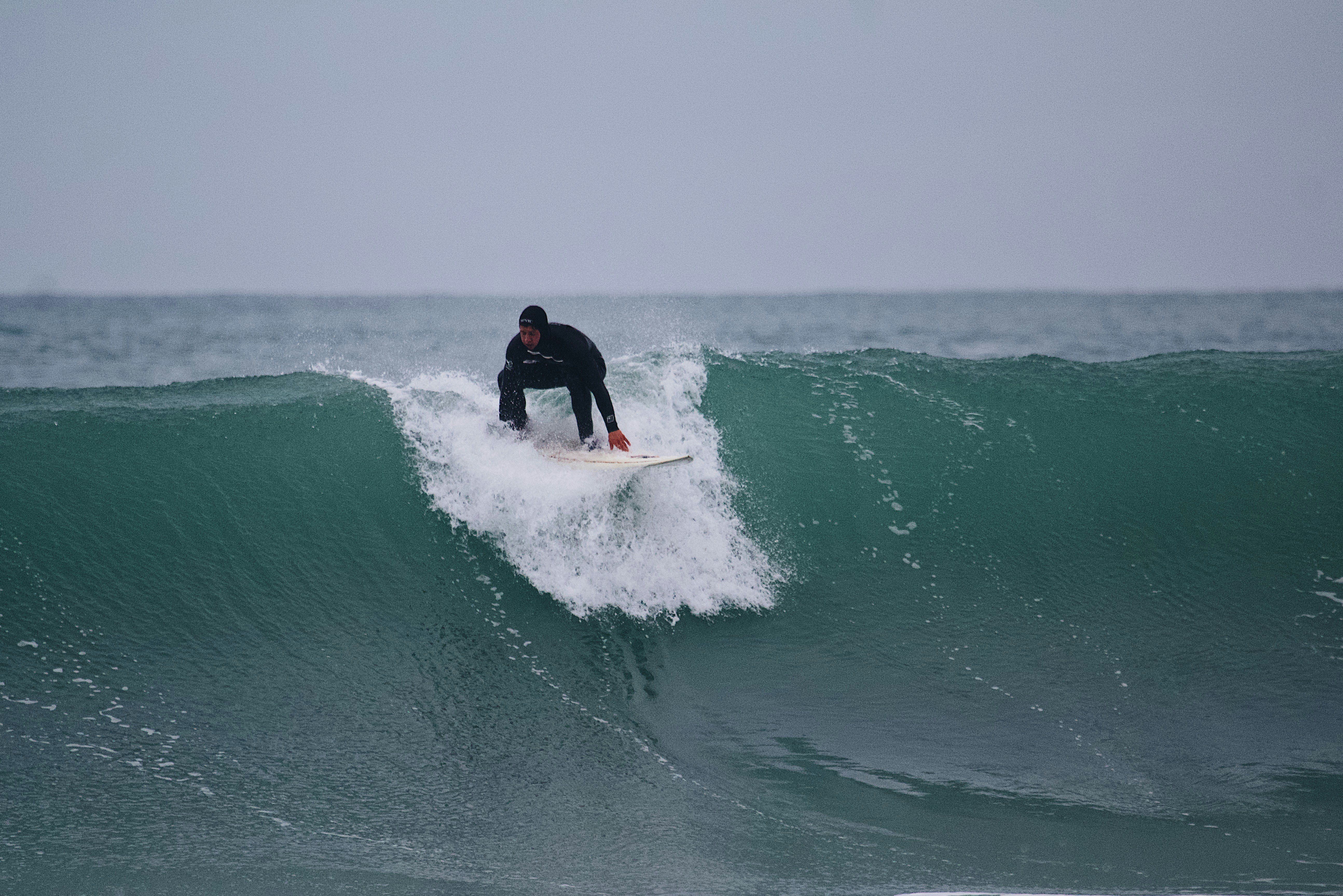 A man riding a wave on top of a surfboard photo – Free Nature Image on ...