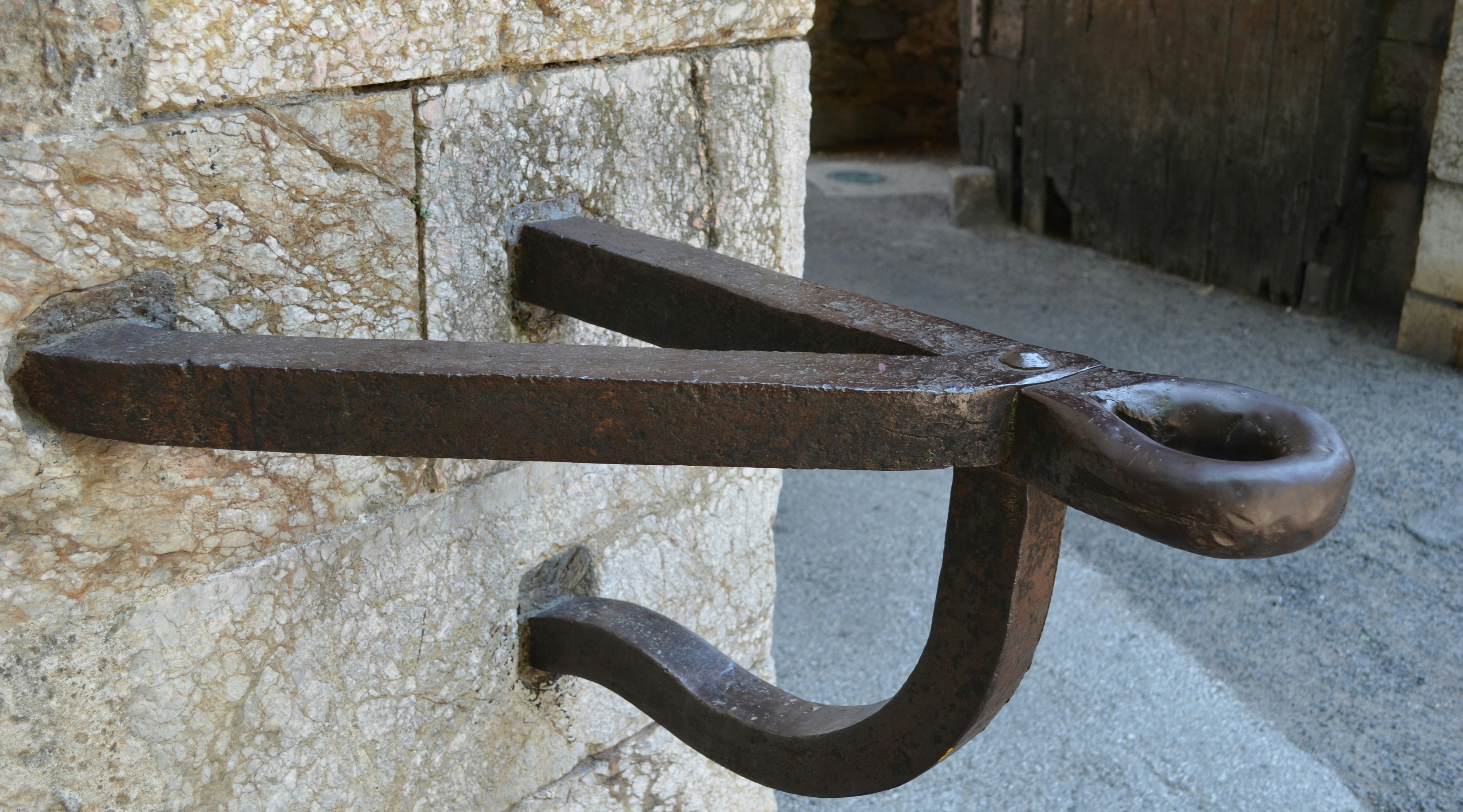 Weathered Iron Hook Anchored to Timeworn Stone Wall