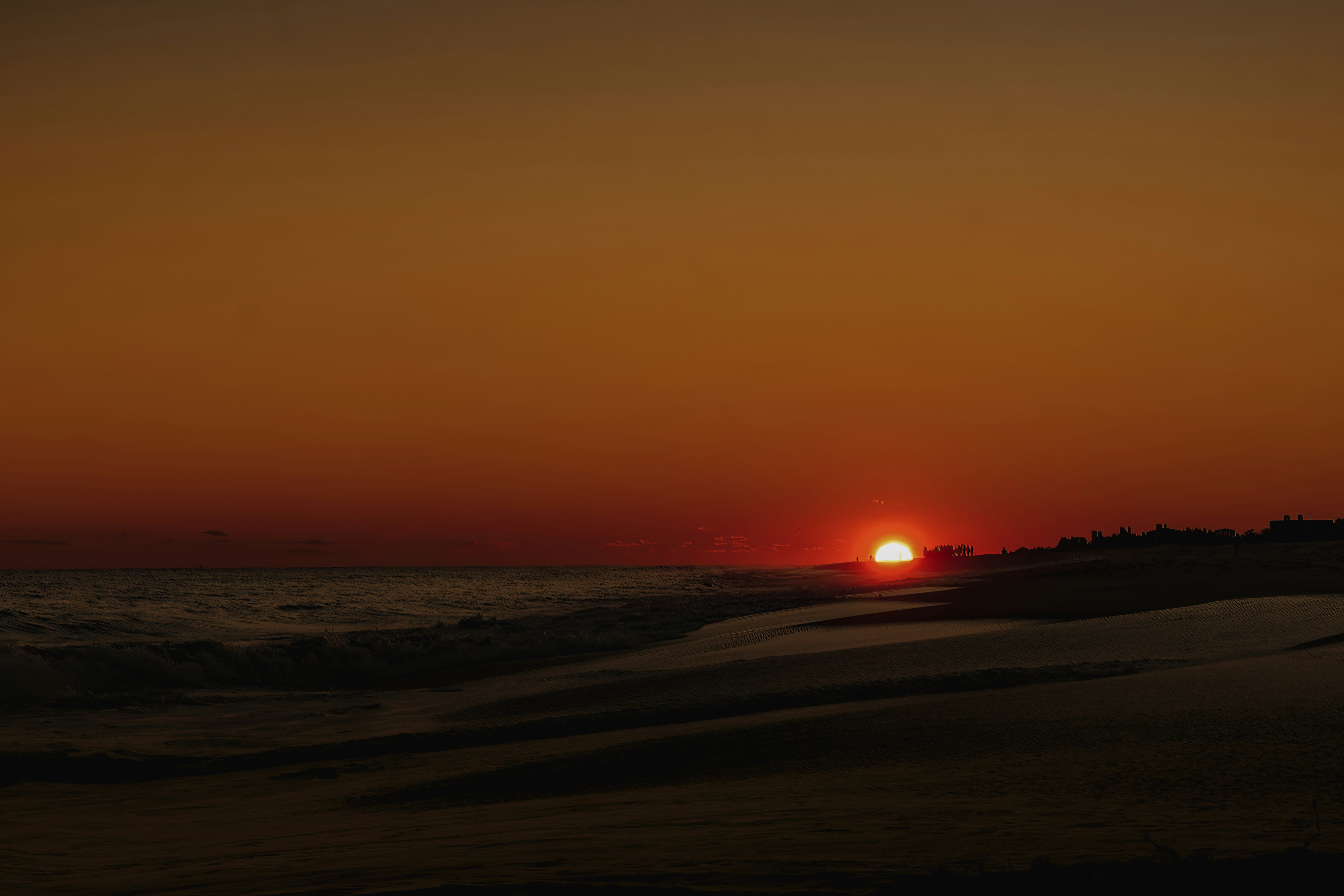 The sun is setting over the ocean on a beach photo – Free Brown Image ...