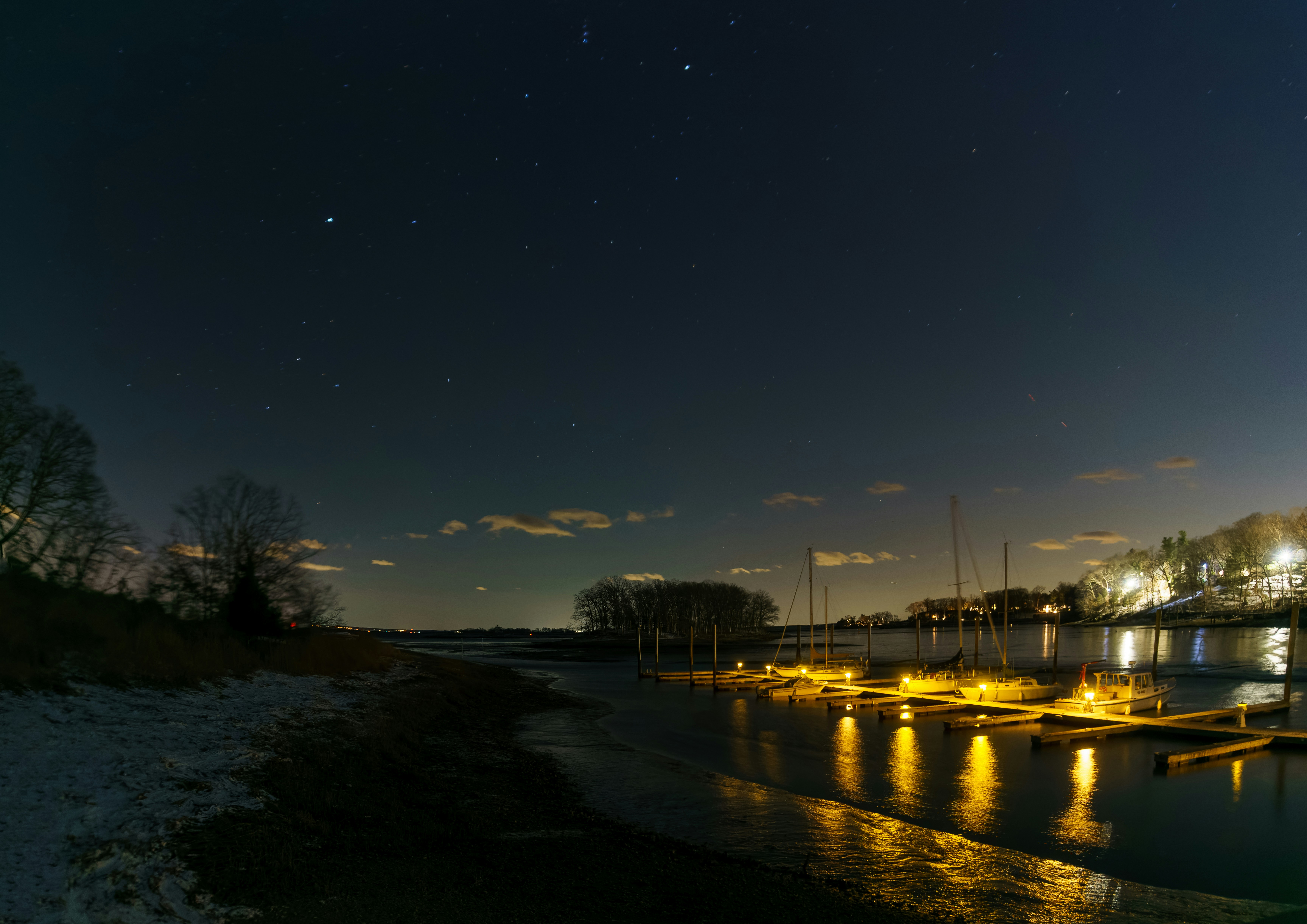 Moonlit Marina: Golden Reflections on a Star-Filled Waterfront