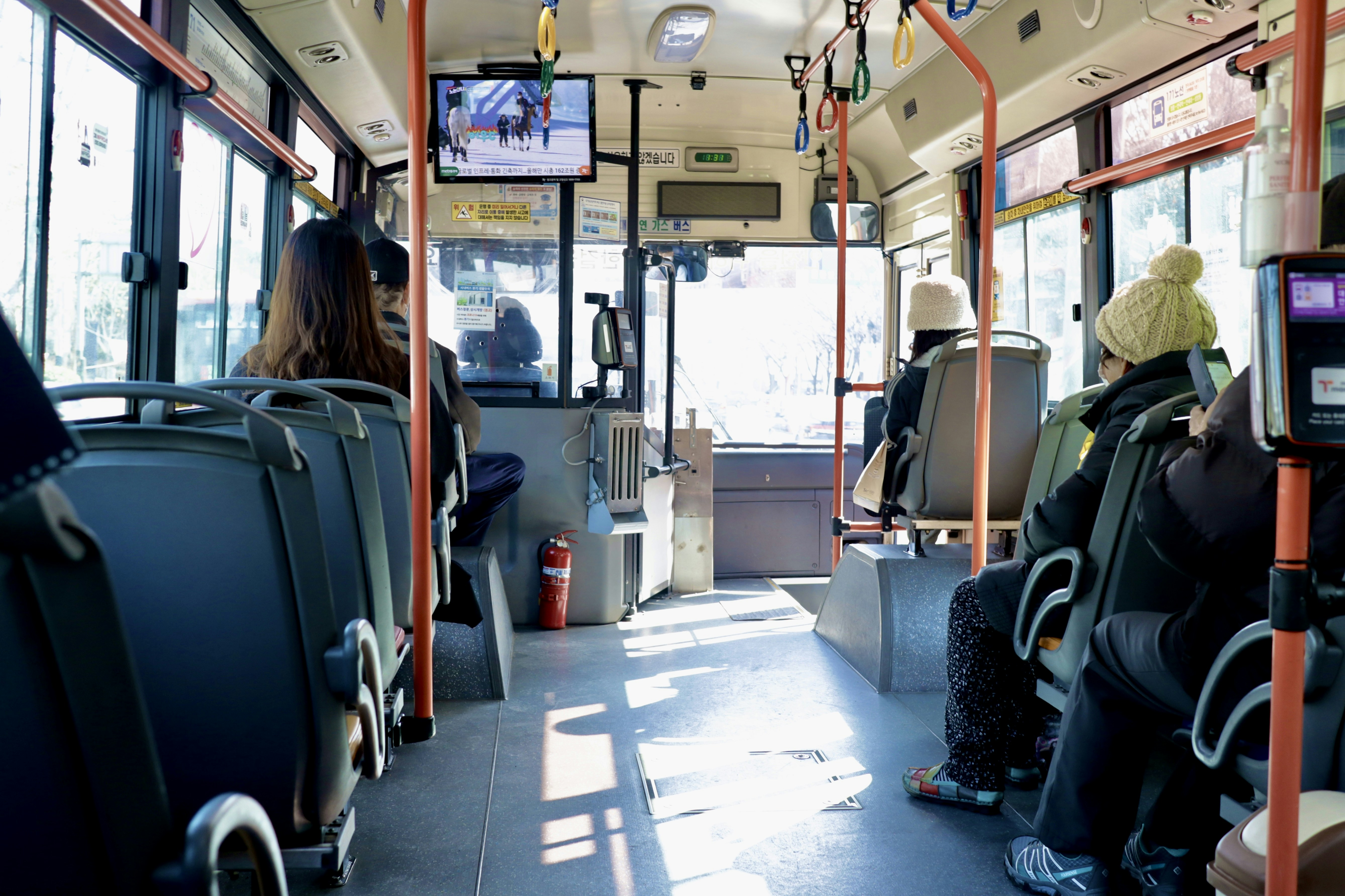 A group of people sitting on a bus next to each other photo – Free Bus ...