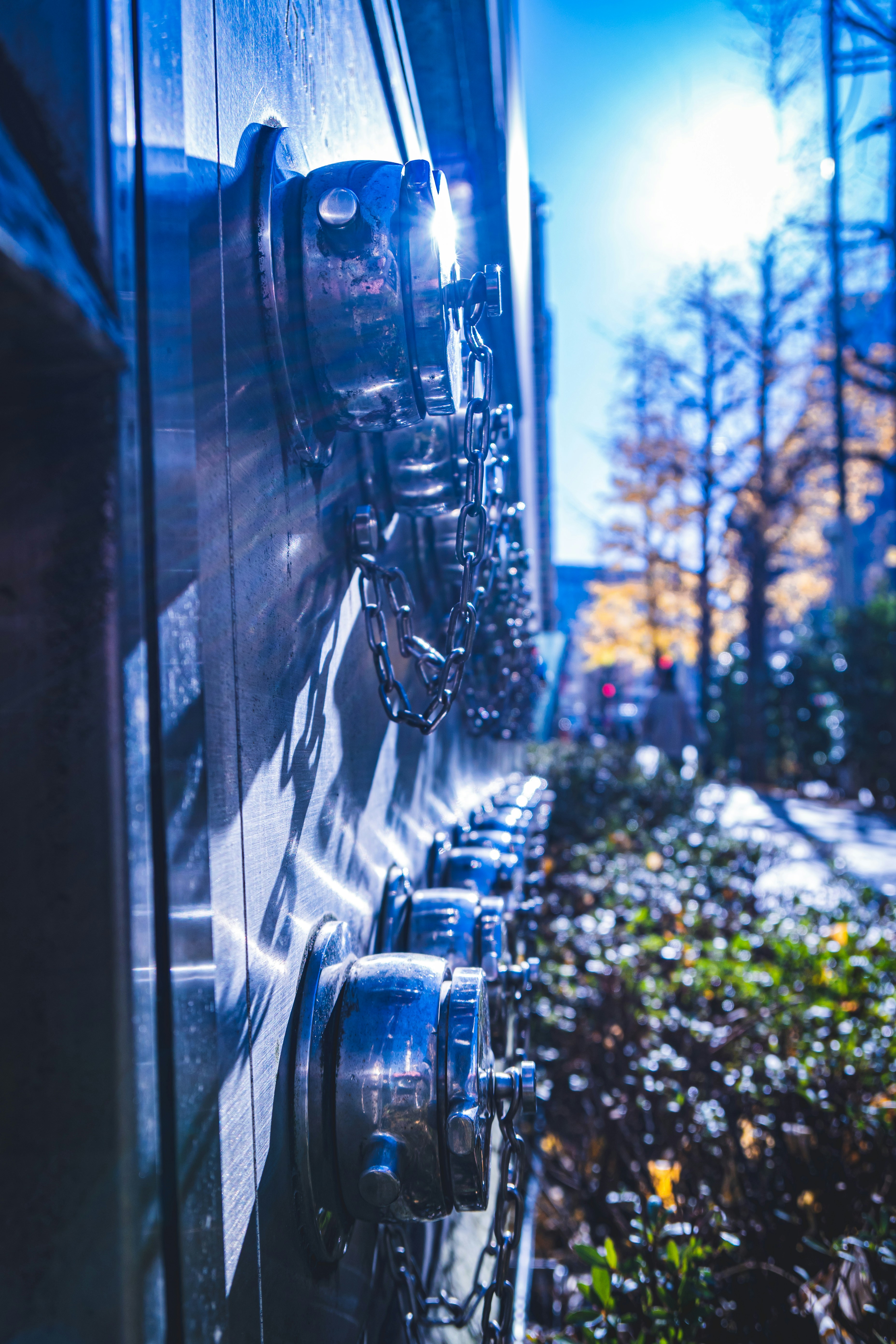 Blue-Glint on the Car: Chains, Latches, and a Sunburst