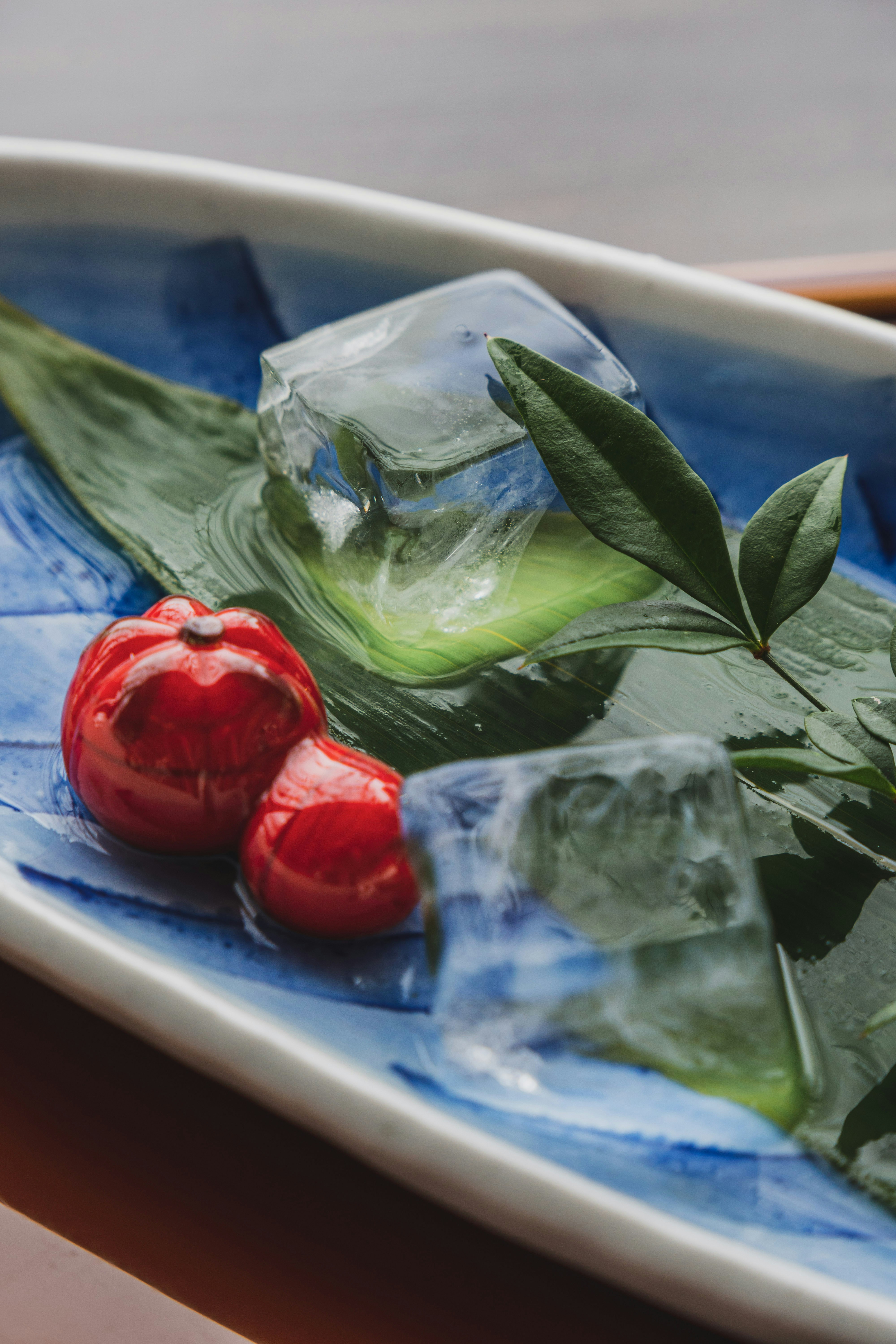 two cherries on a plate with ice cubes