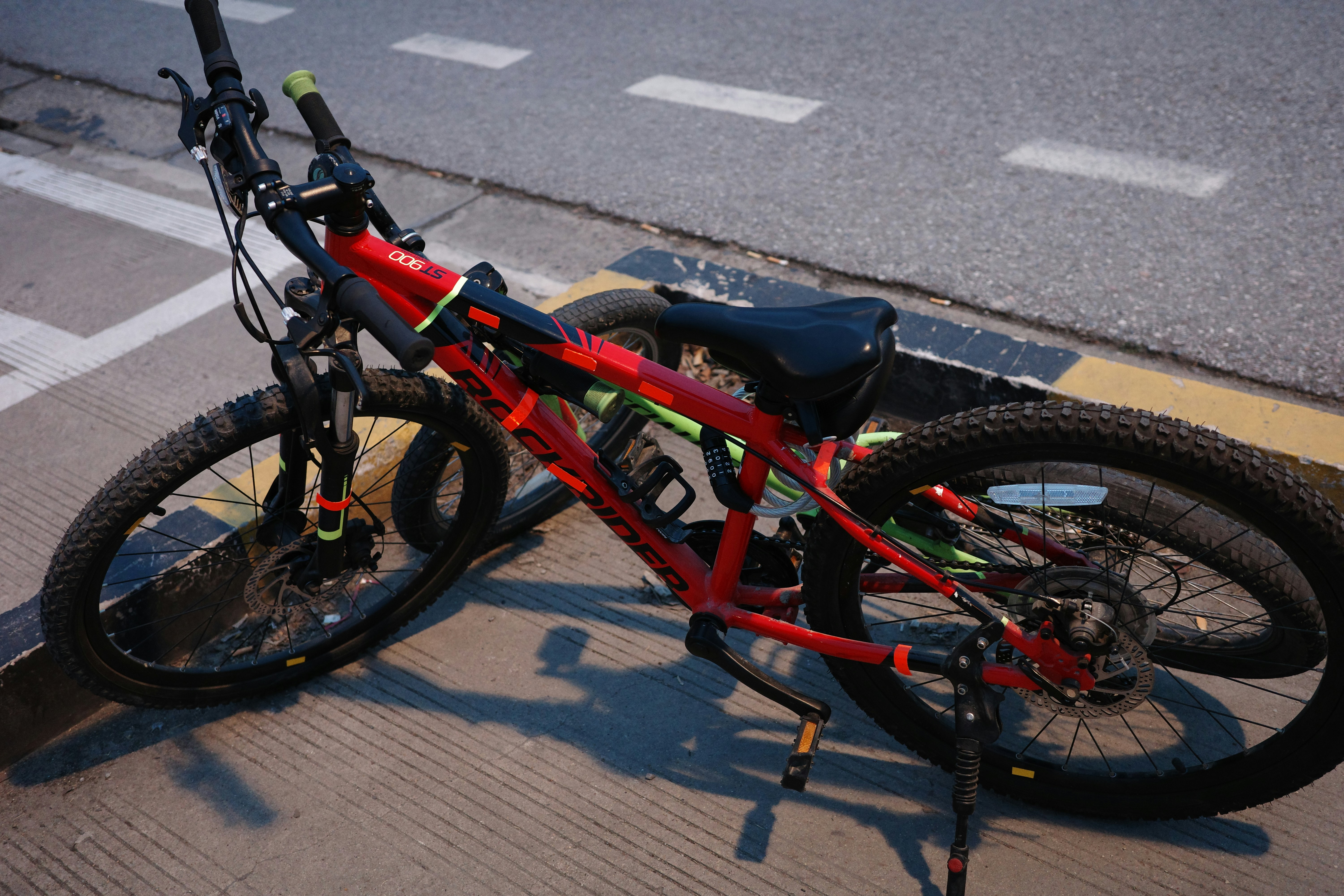 A red bike parked on the side of the road photo – Free Bike Image on ...