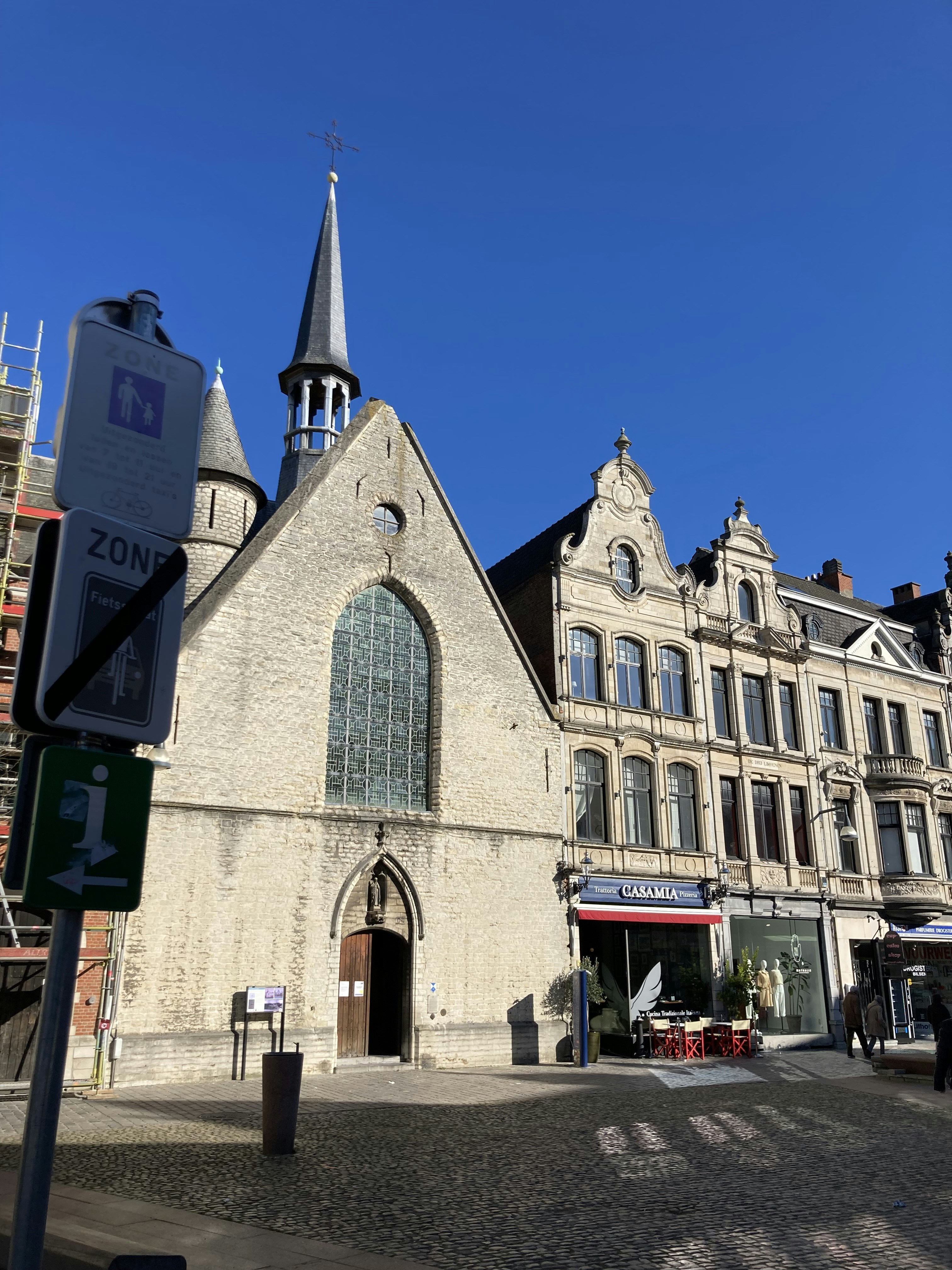 Historic church juxtaposed against elegant townhouses under a clear blue sky. The scene captures the charm of urban architecture.