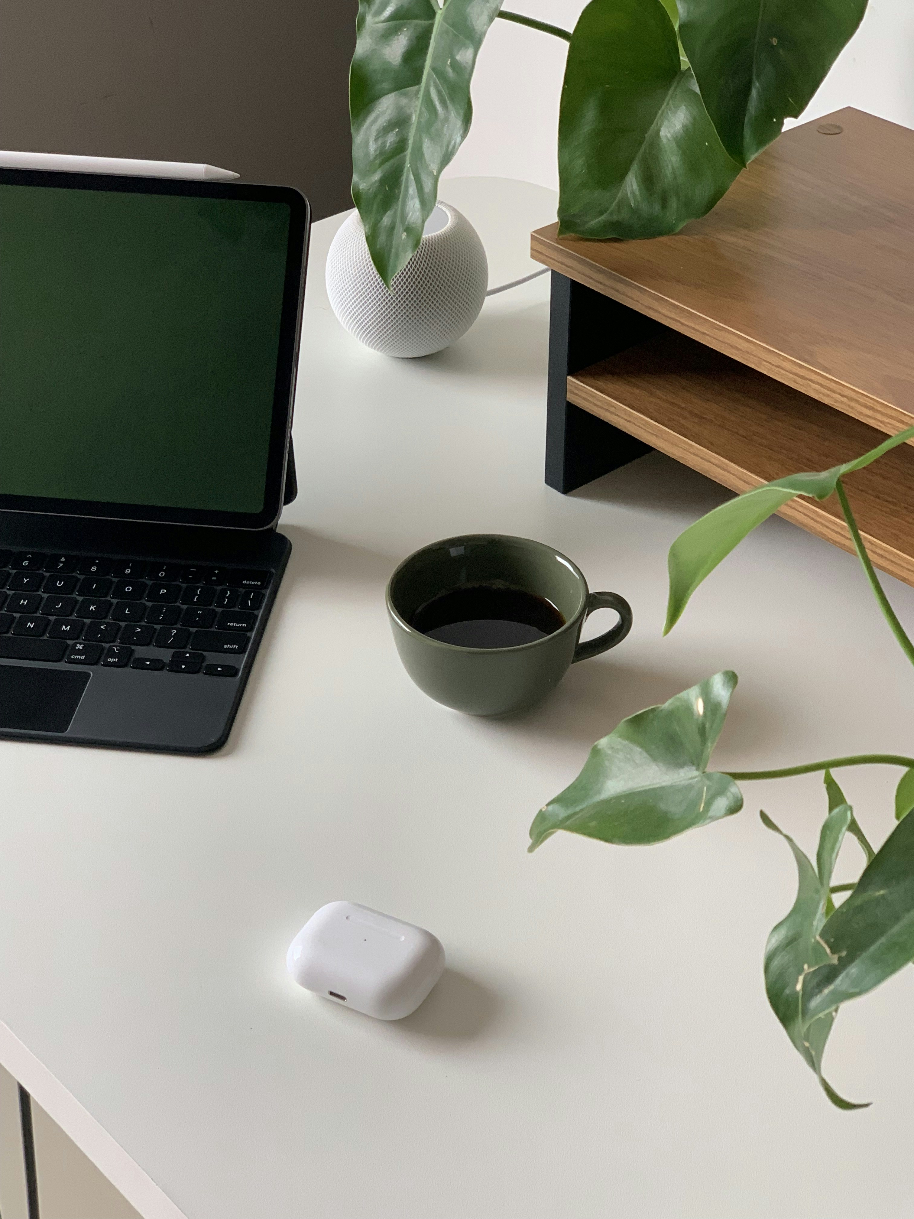 Minimalist workspace featuring a tablet, coffee cup, and potted plant, creating a calm and inviting atmosphere.
