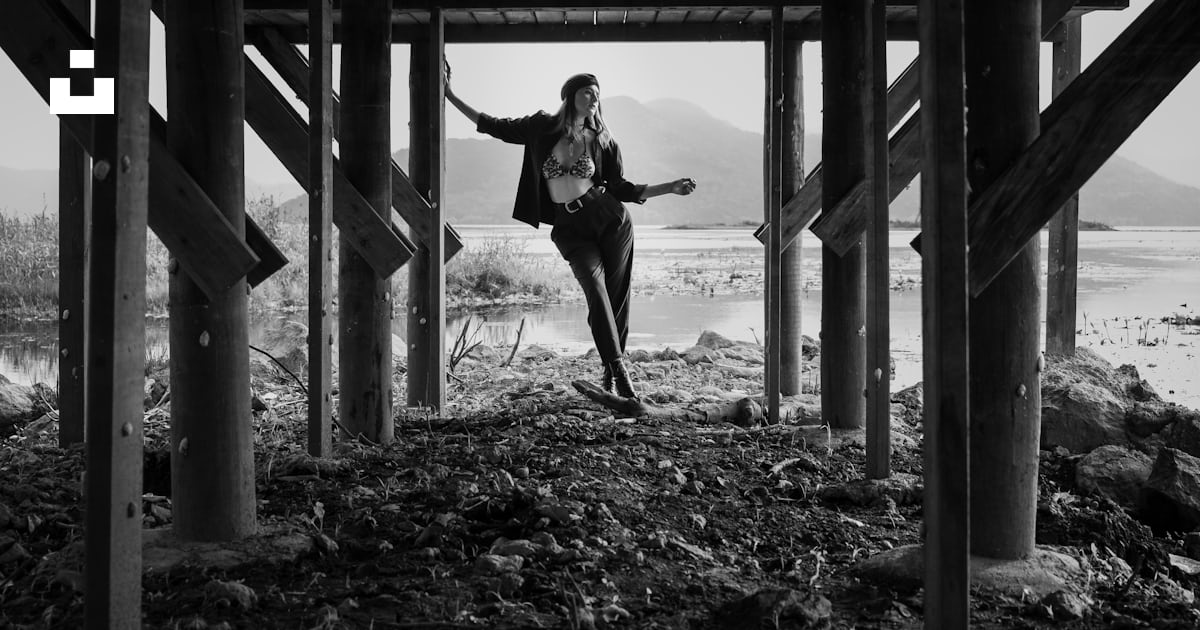 Una Foto En Blanco Y Negro De Una Mujer Parada Debajo De Un Puente Foto