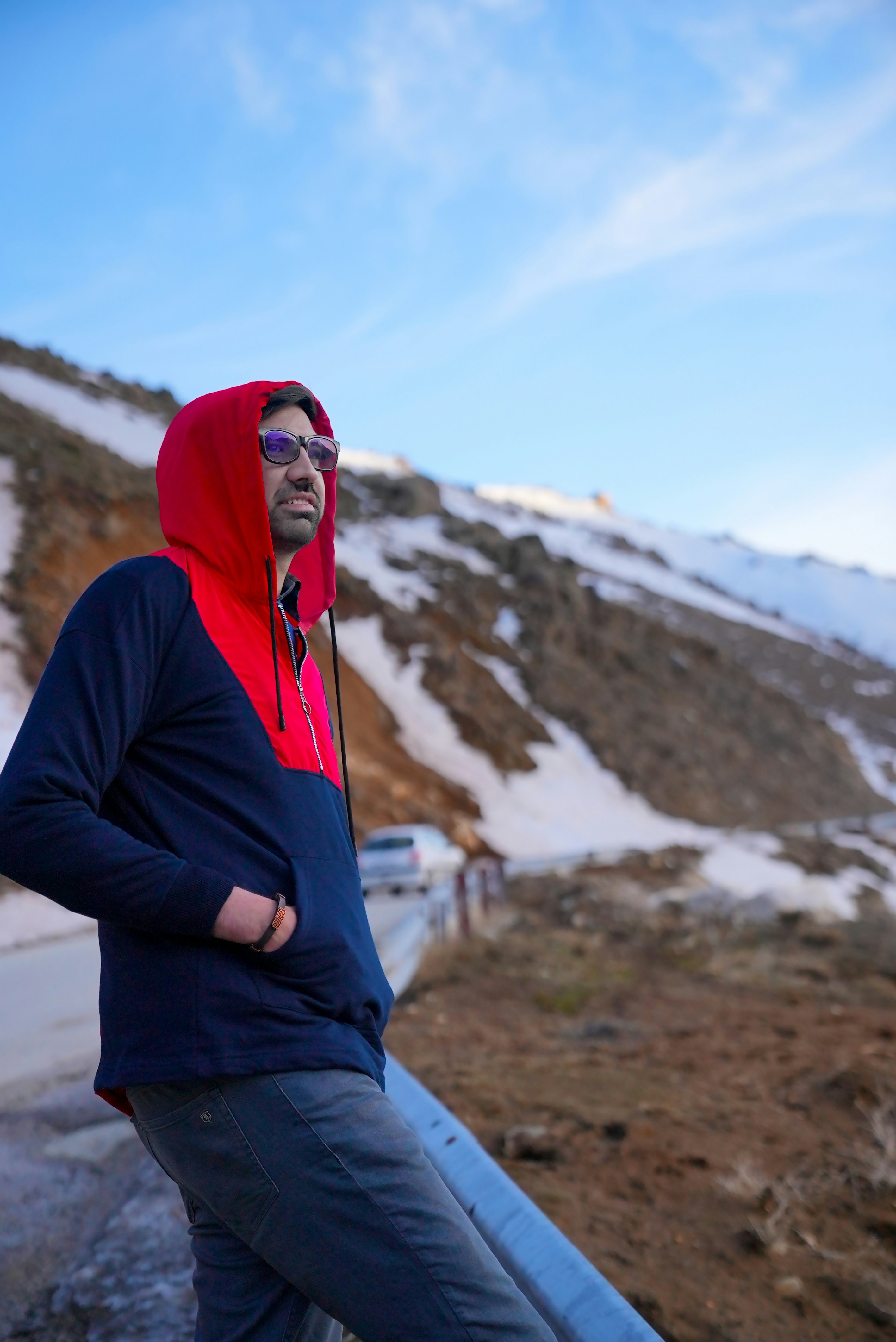 Crimson Hood on a Snow-Dusted Alpine Road