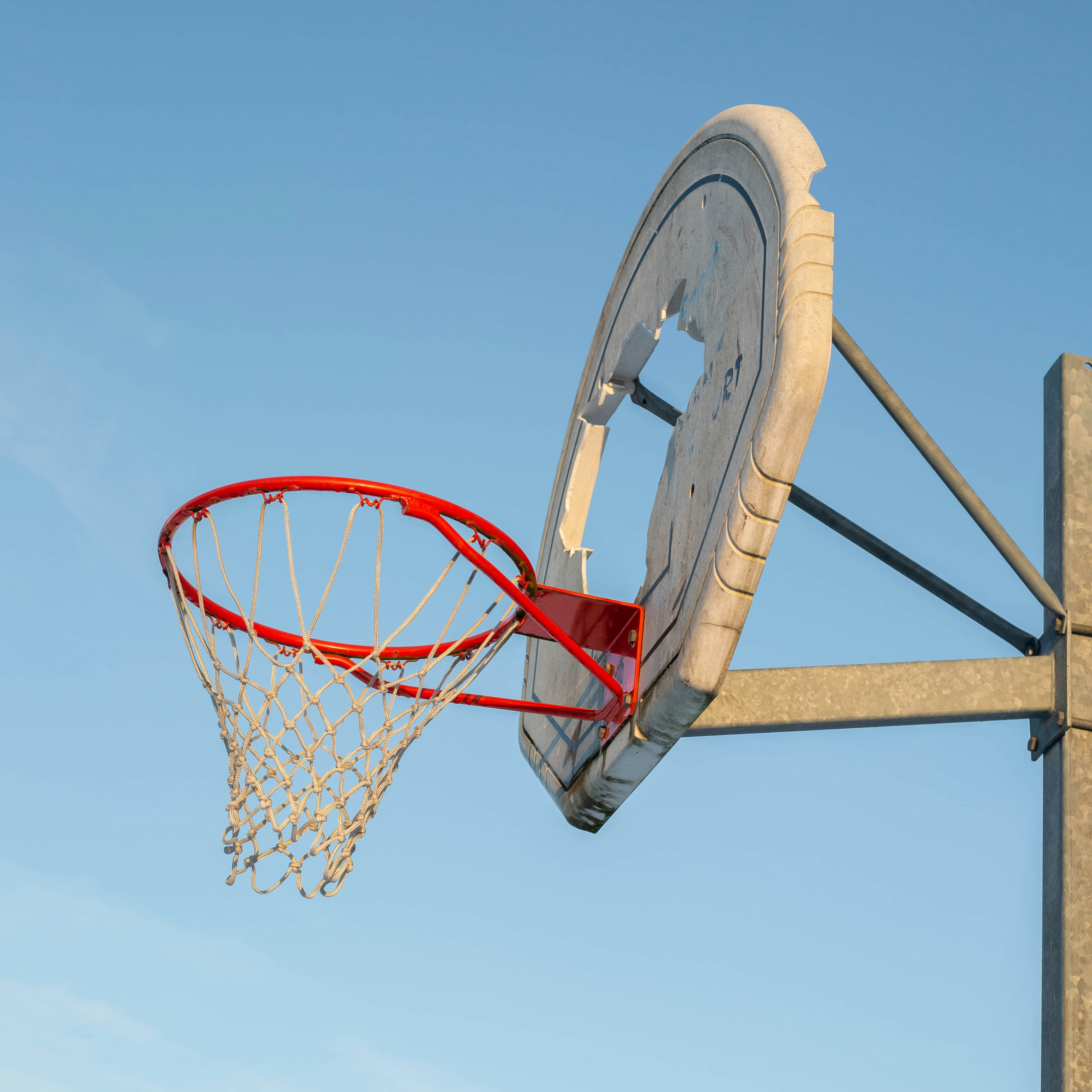 A basketball going through the rim of a basketball hoop photo – Free ...