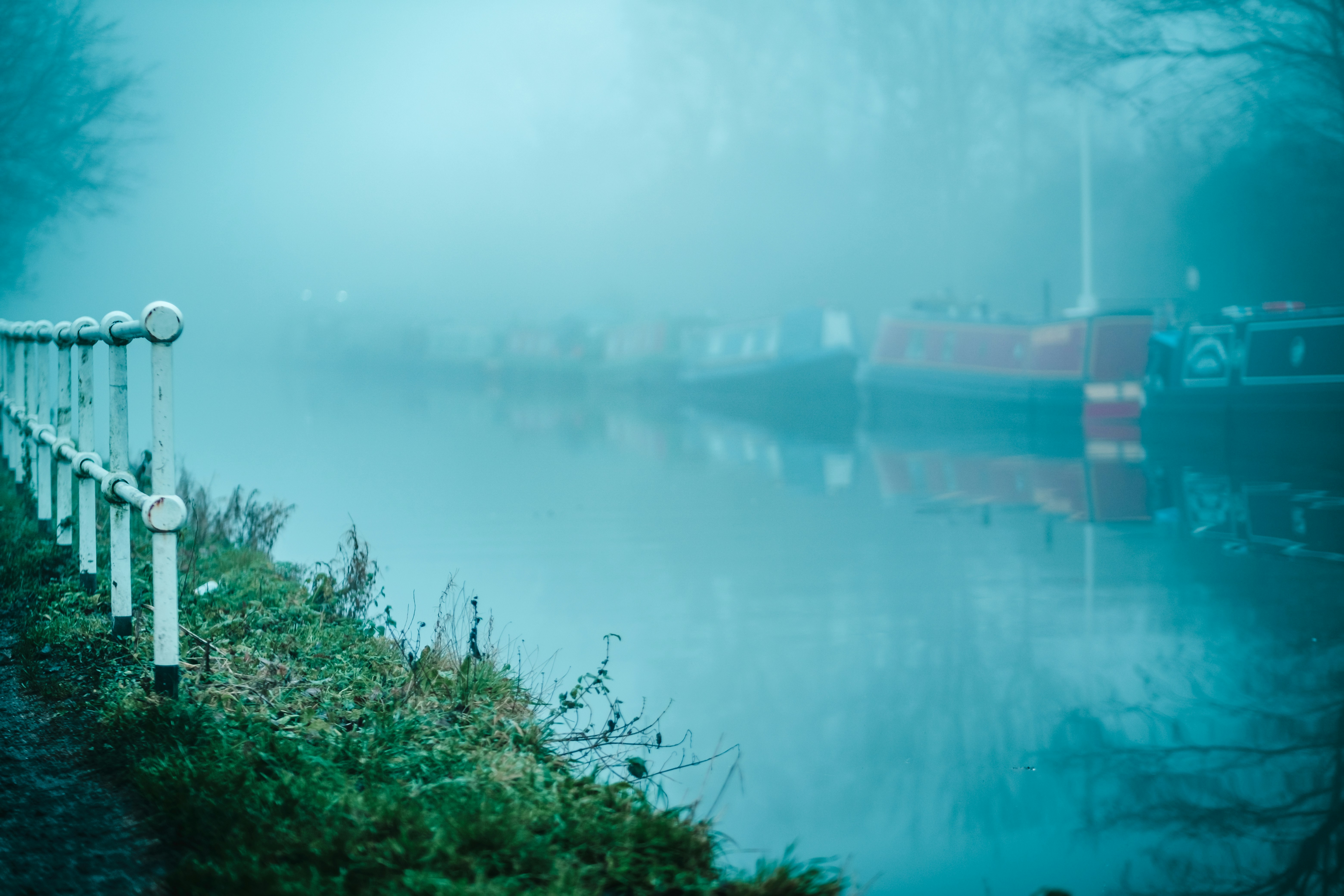 Blue Mist by the Canal: Railings Guiding Through Fog and Silence