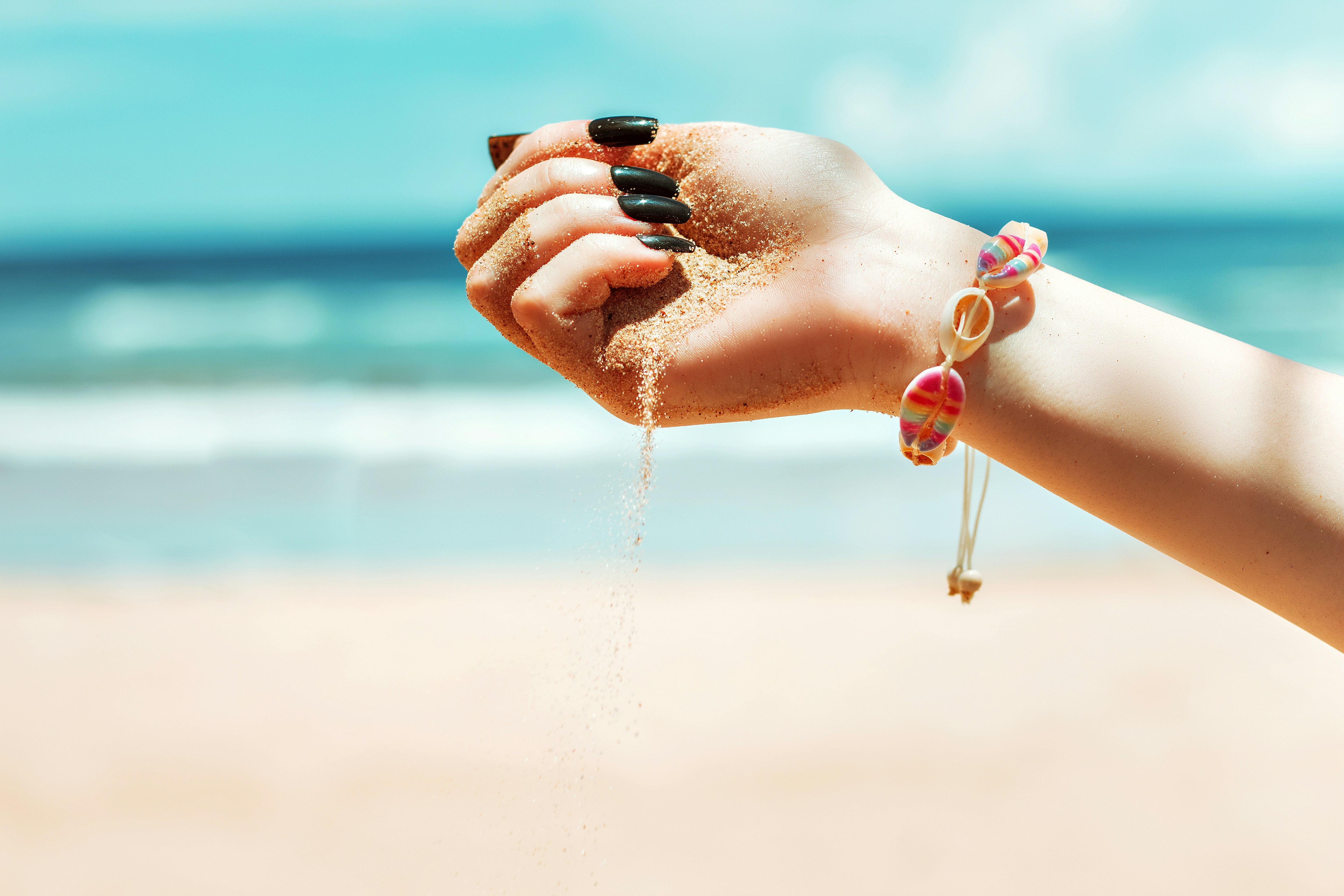 A person holding sand in their hand on the beach photo – Free Brown ...
