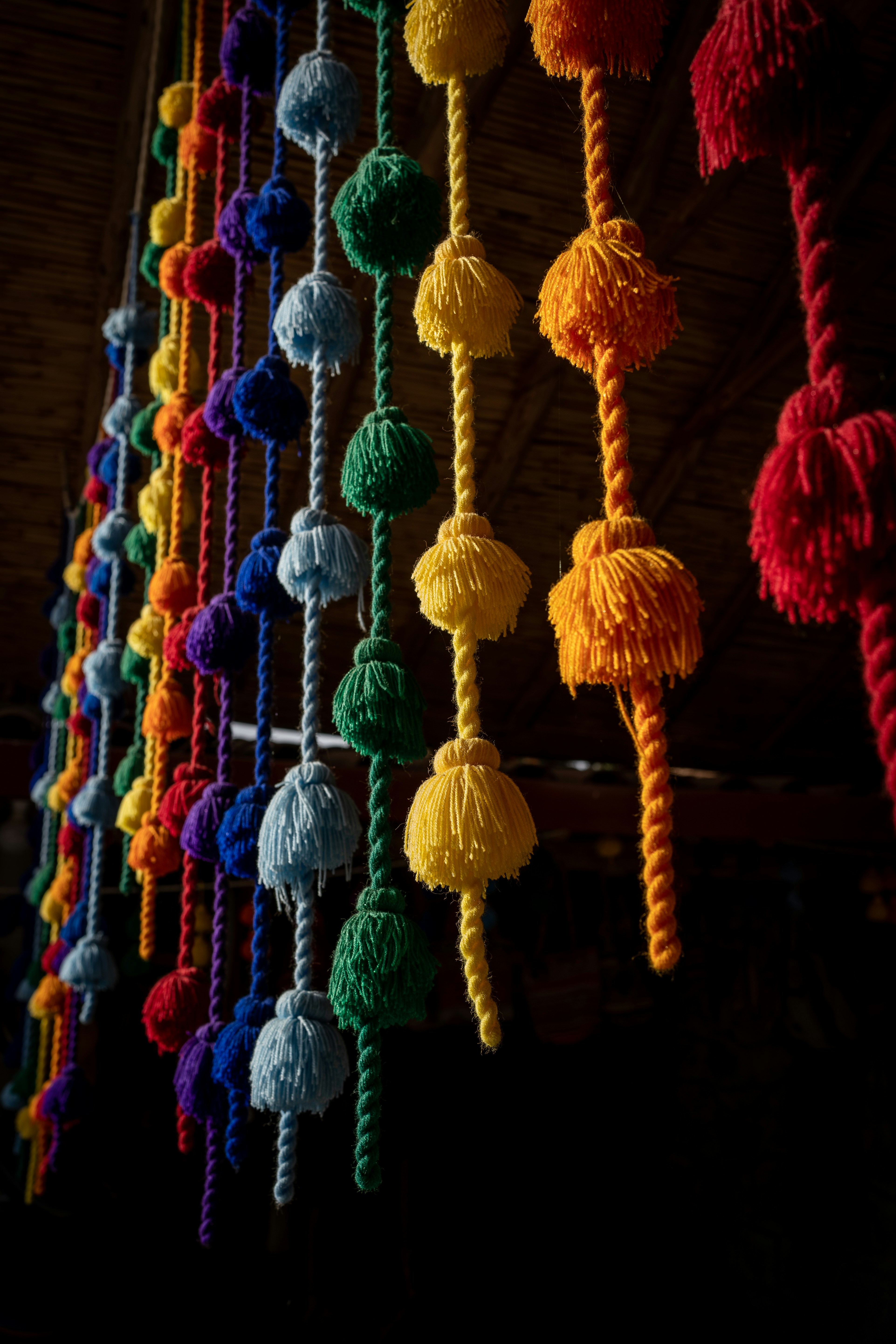Vibrant tassels in various colors hang from the ceiling, creating a lively atmosphere. The intricate details highlight traditional craftsmanship.