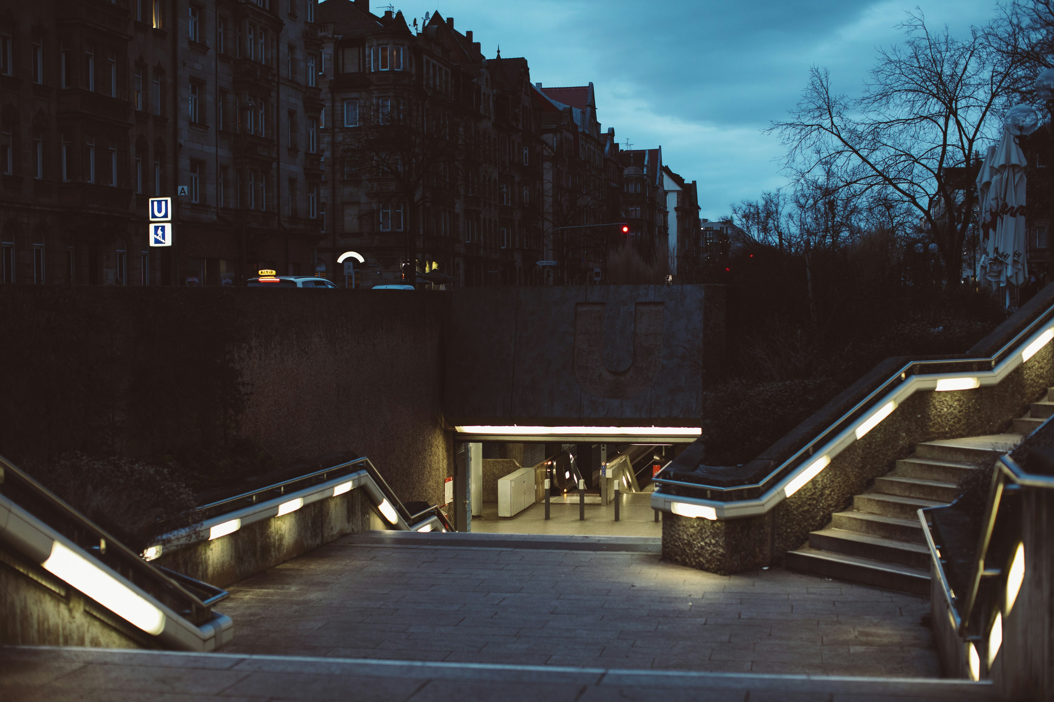 Blue Hour Threshold: Neon-Lit Staircase Framing a Quiet Underground Entrance