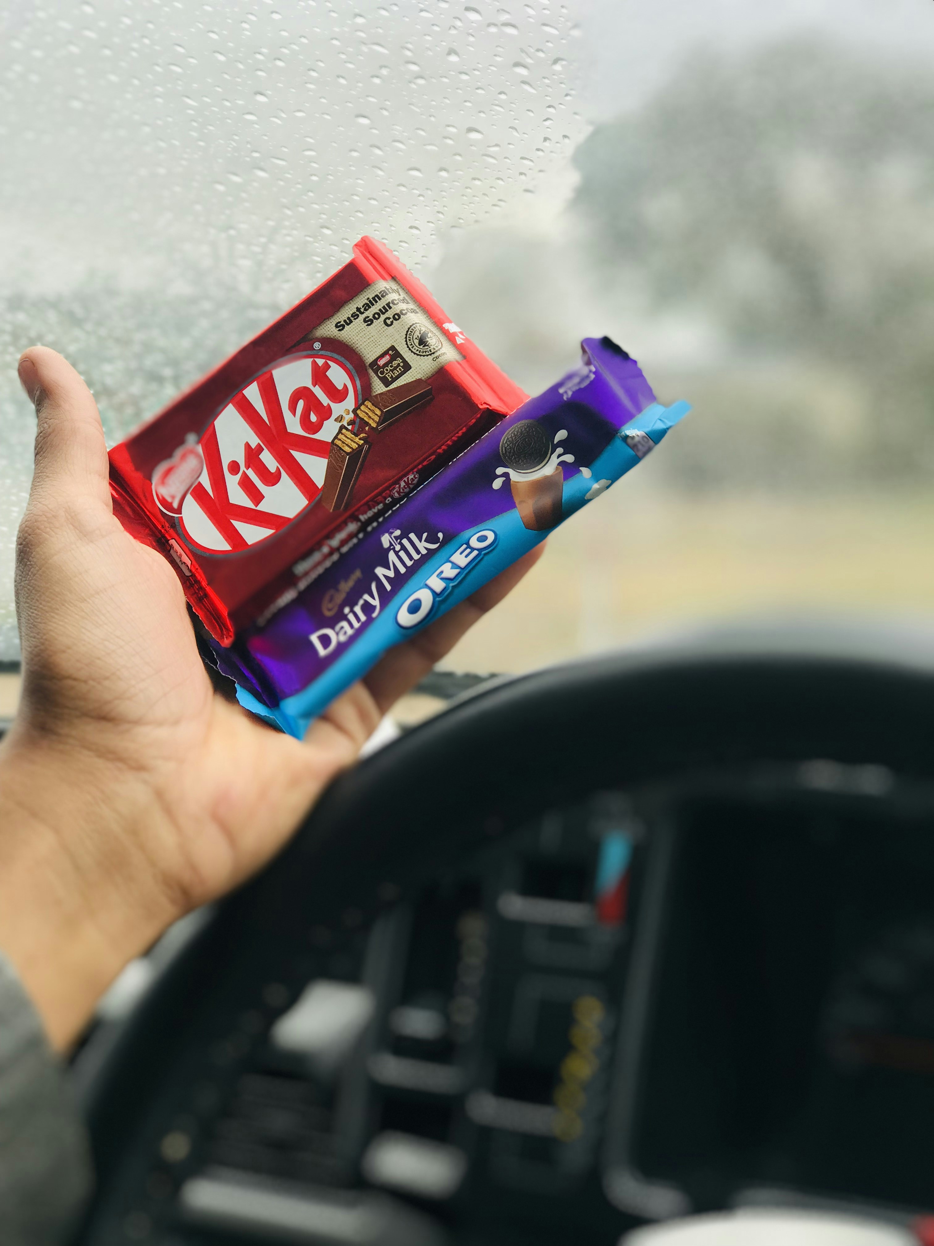 Pocket Treats in Hand: Chocolate Bars Framed by Car Window